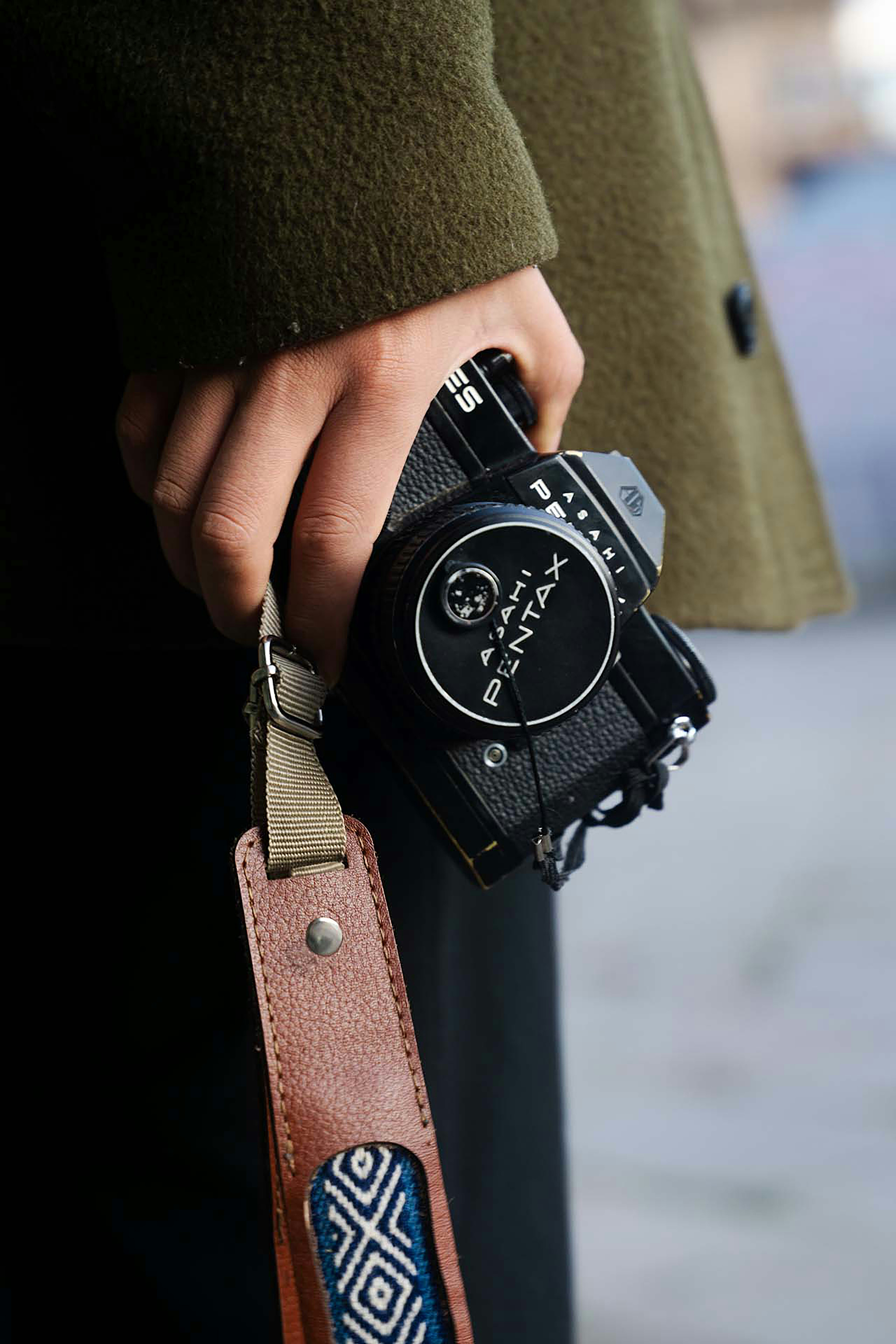 Grip of Time: A Vintage Pentax Clutched Under Olive Light