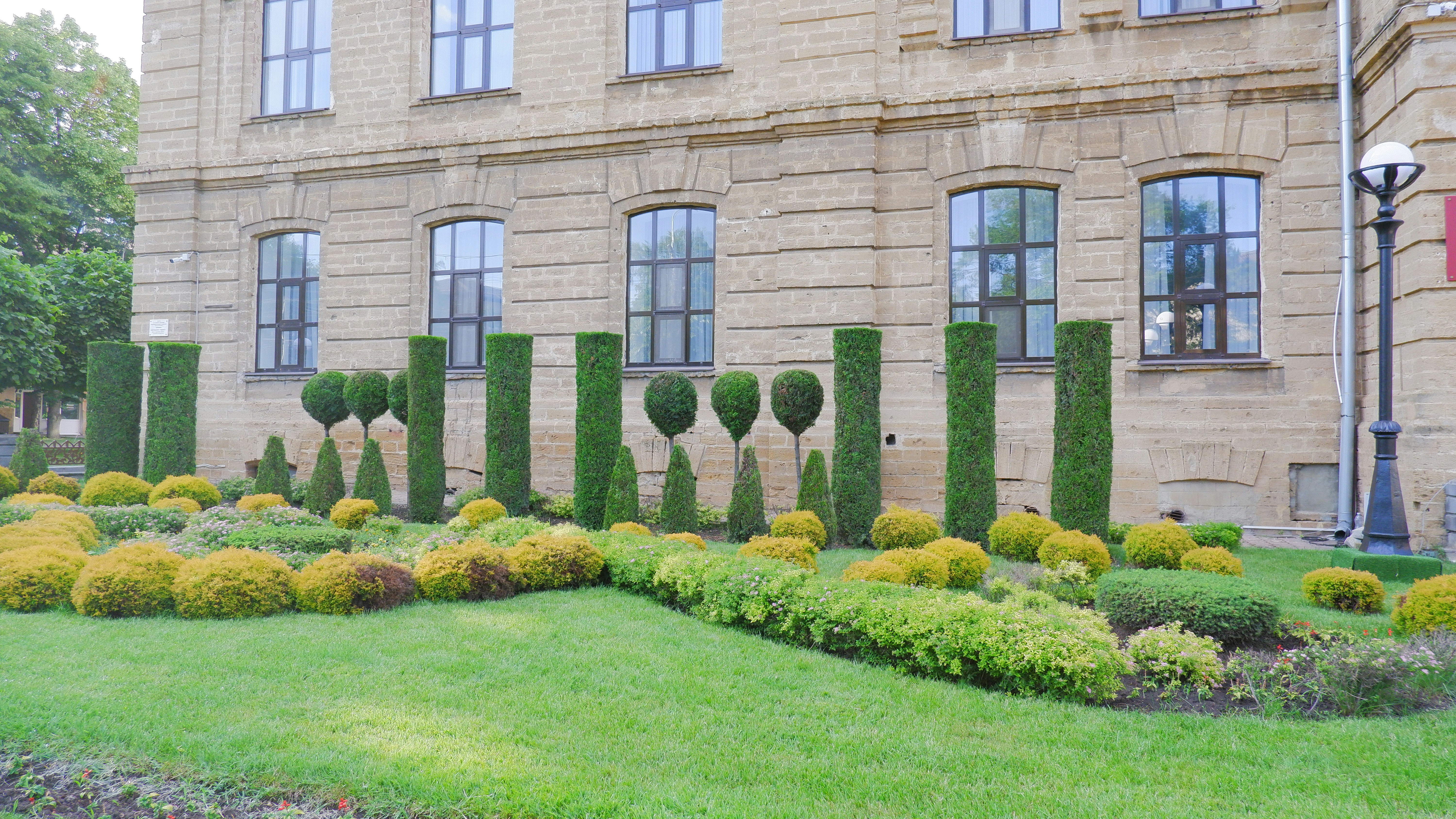 A building with a lawn and bushes in front of it photo – Free ...