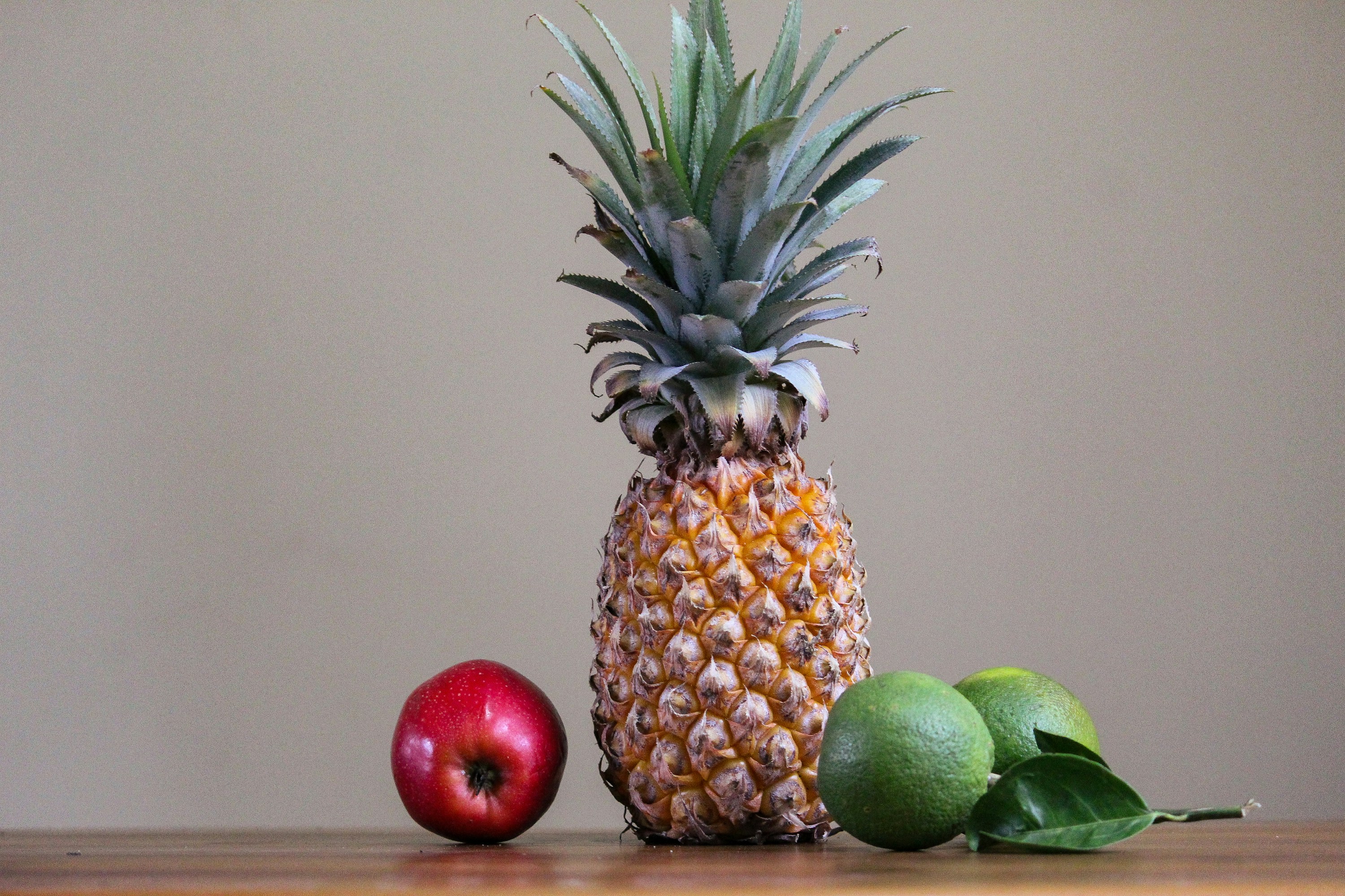 Centerstage Pineapple: Still Life with Apple and Lime on Wood