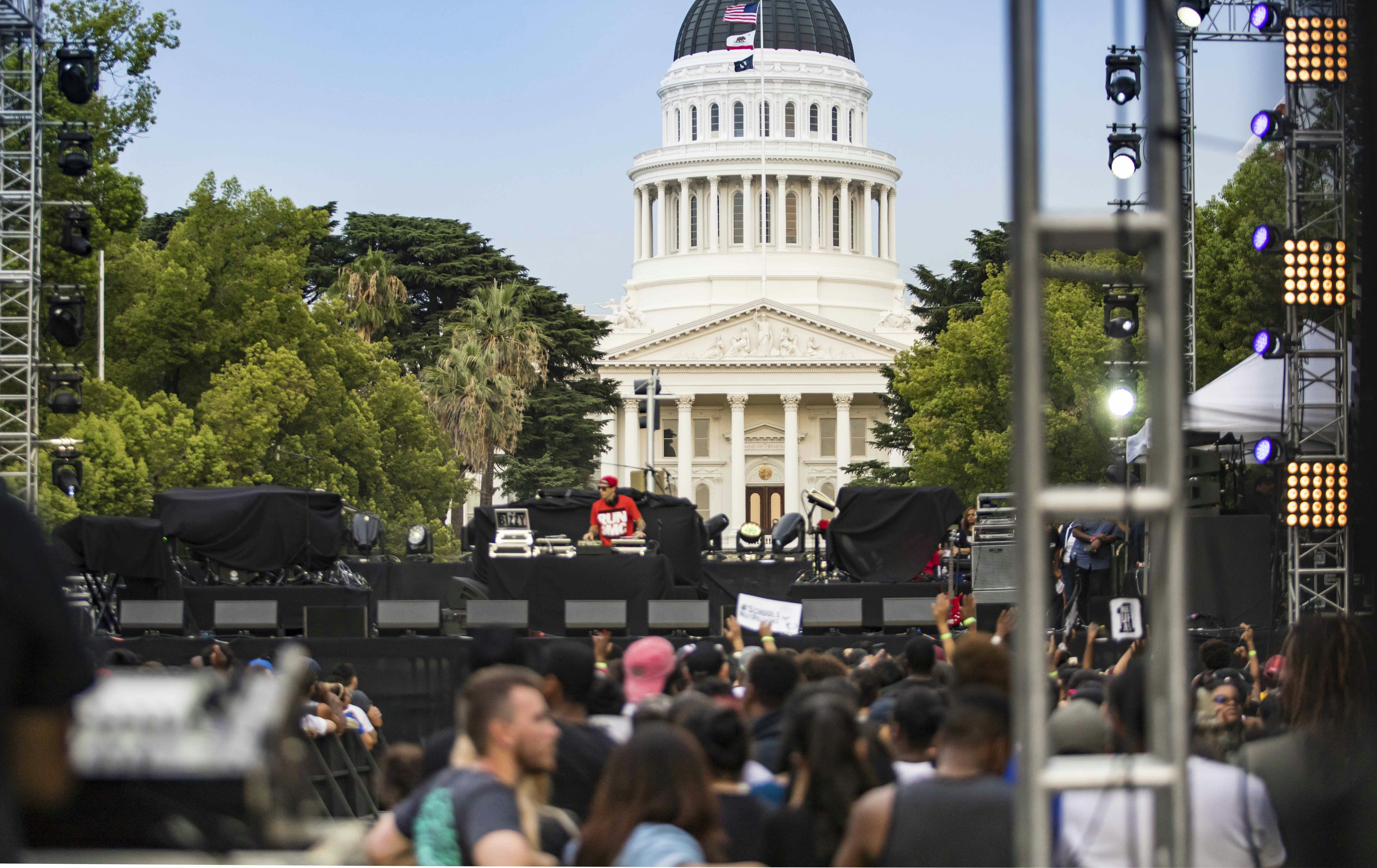 A large crowd of people in front of a white building photo – Free ...