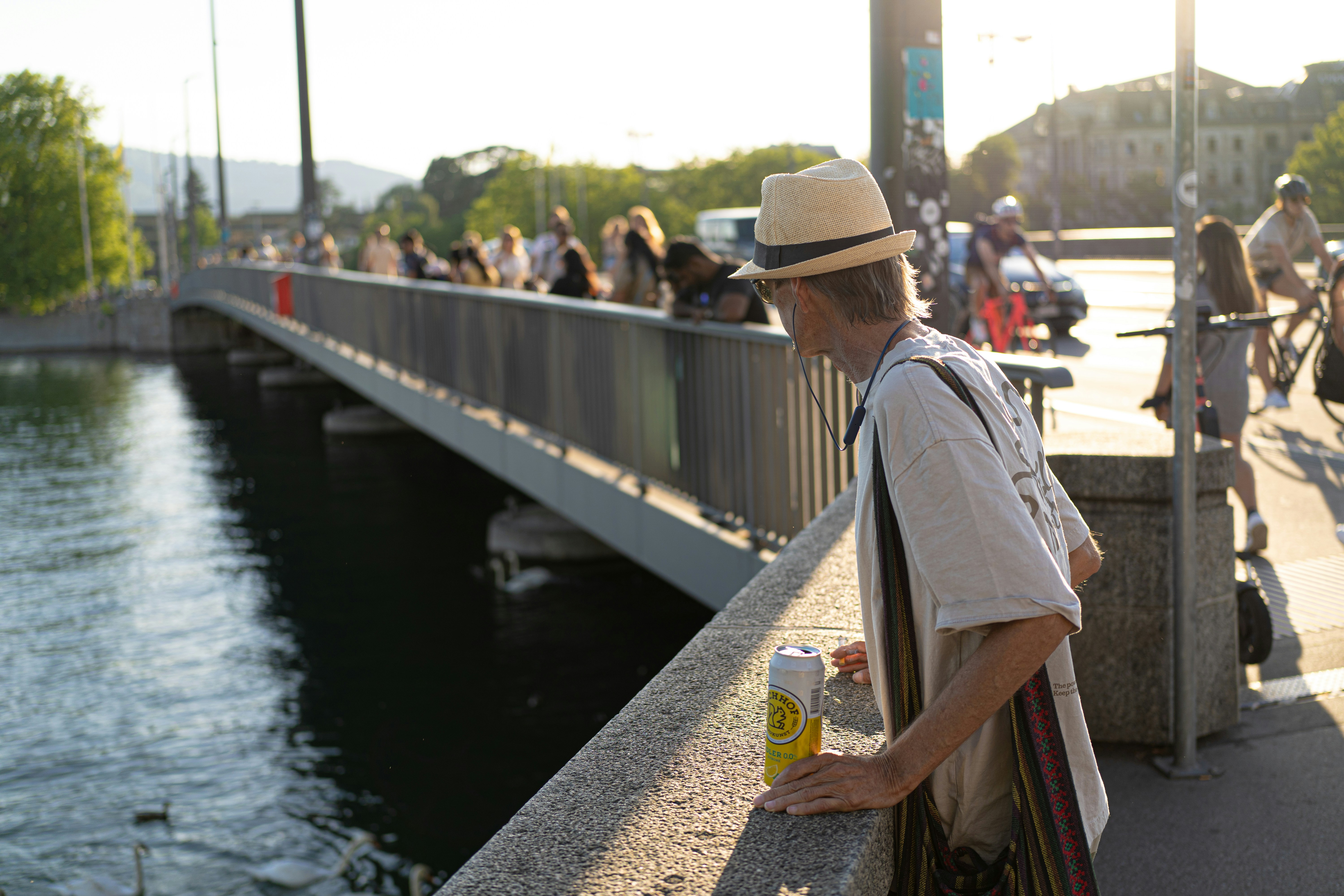 Bridgeside Quiet: A hat-wearing observer by the river