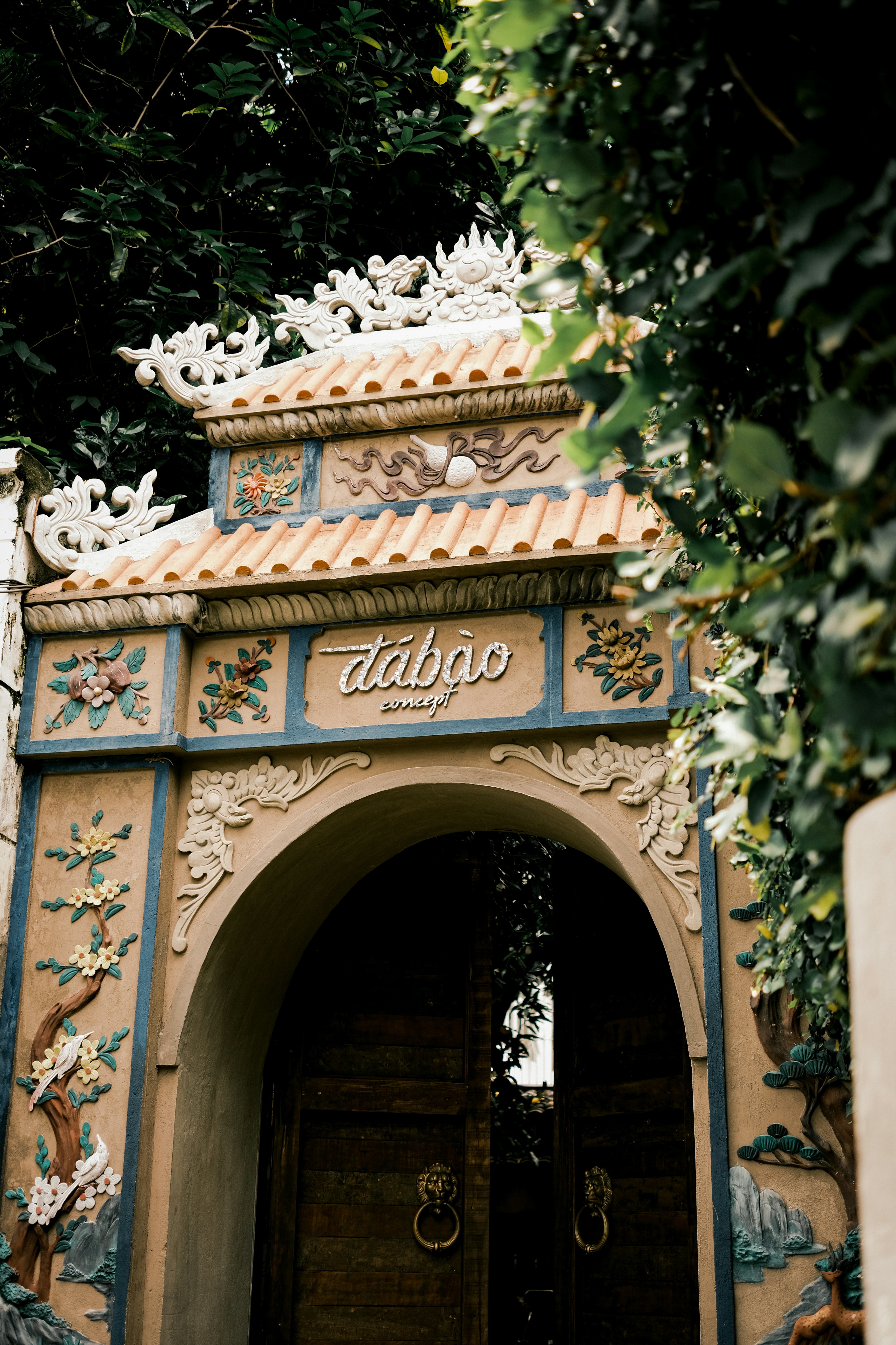 Petal-Relief Arch Gate: Terracotta Roof Framed by a Garden Canopy