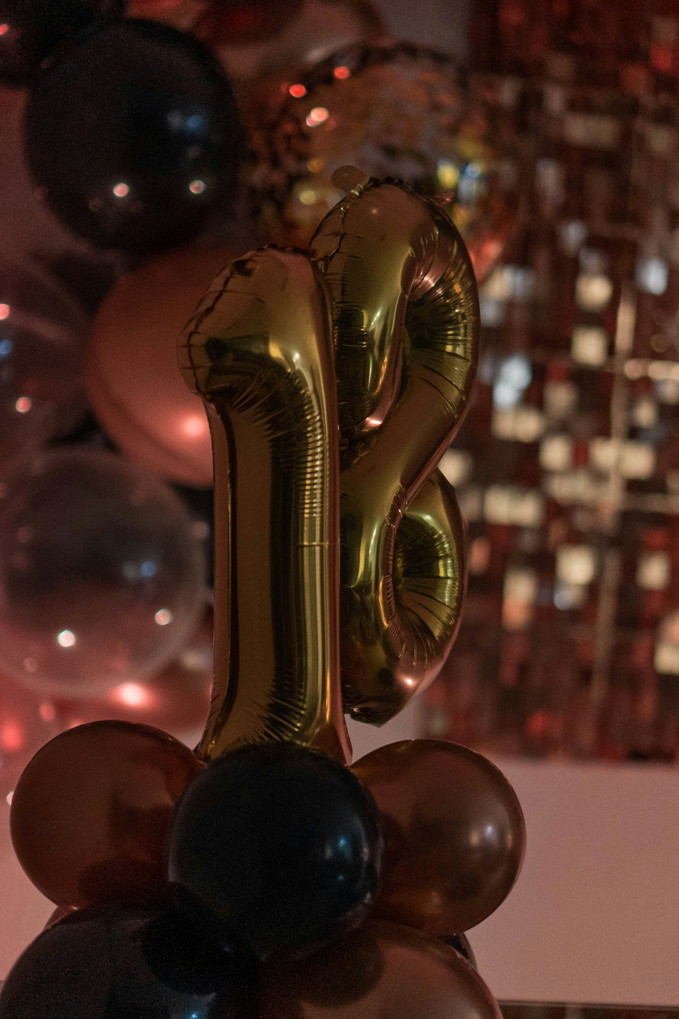 Gold Number One Surrounded by Balloons in a Warm, Moody Party Scene