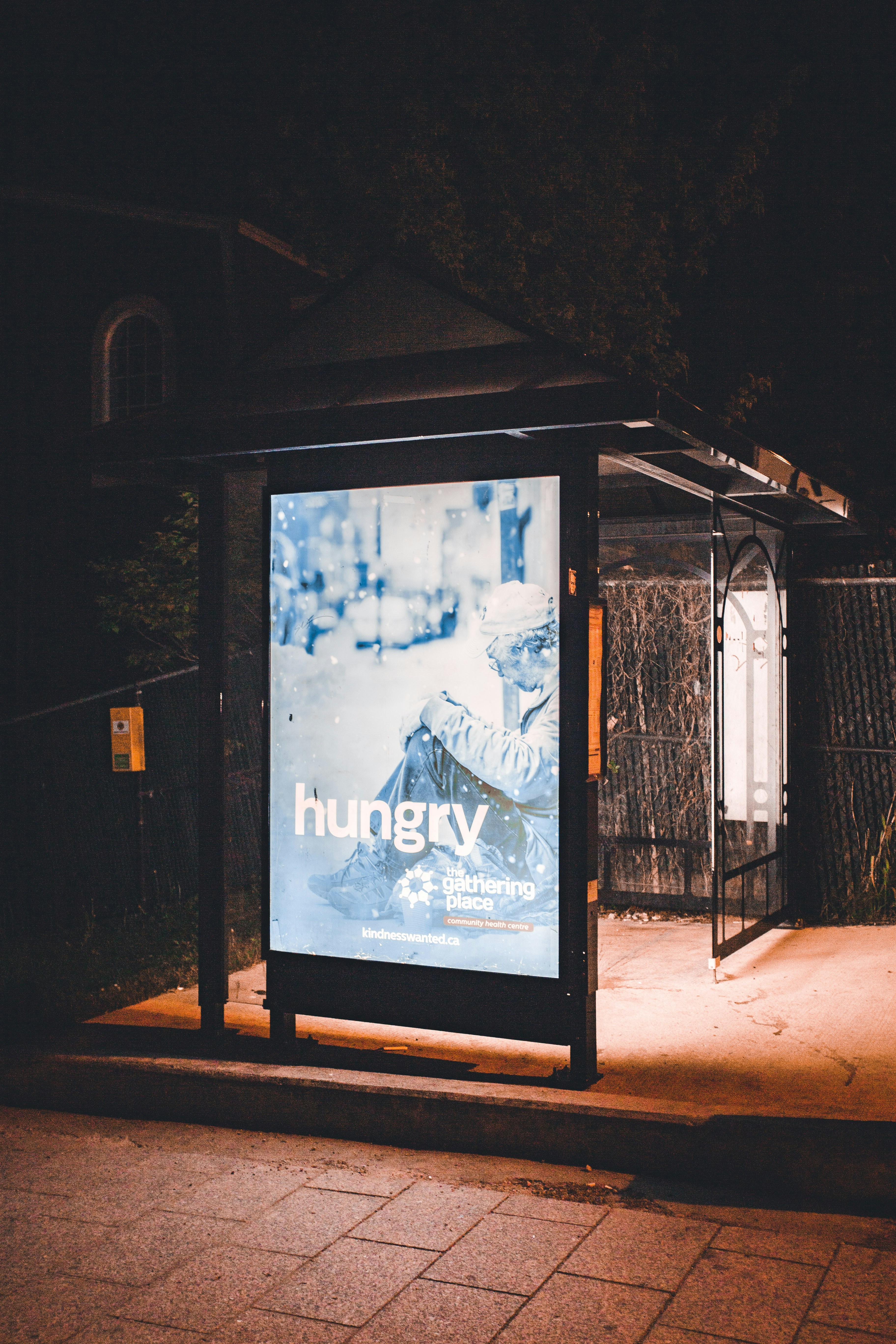 Blue-Glow Poster at a Quiet Night Bus Stop