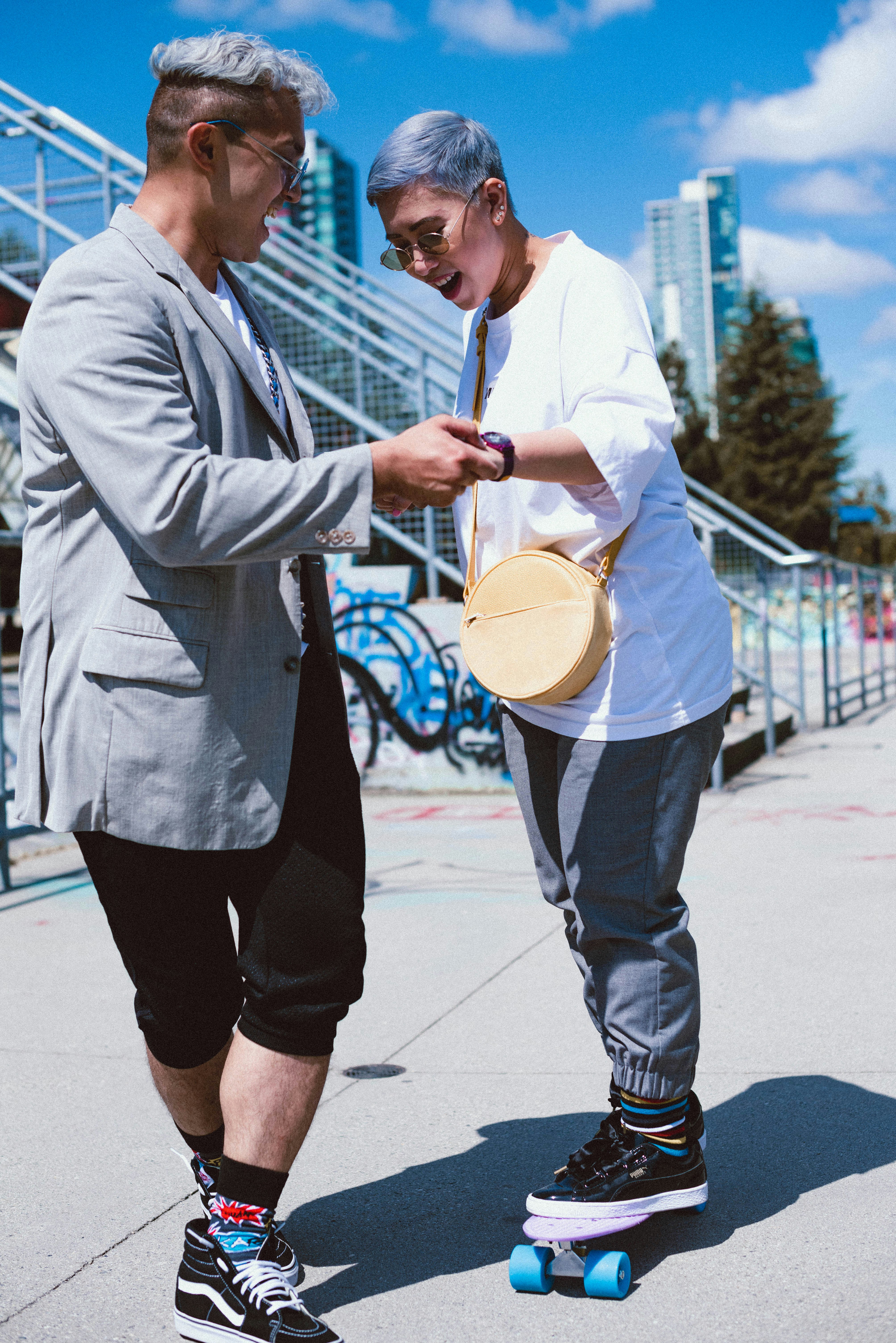 Two friends share a lively moment at the skatepark after a wrist-watch reveal