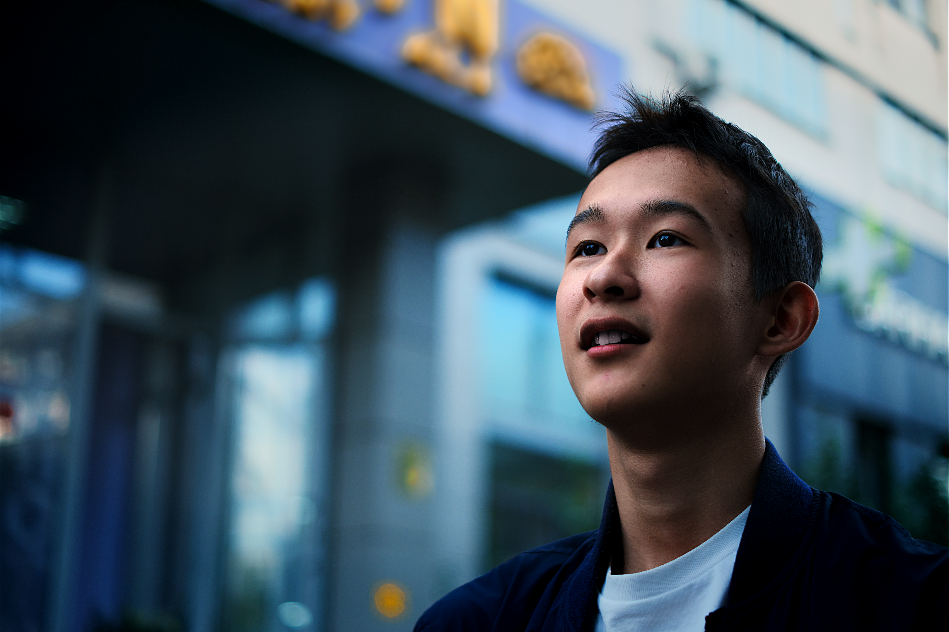 Urban Portrait: A Young Man Amid Neon-Blue Reflections