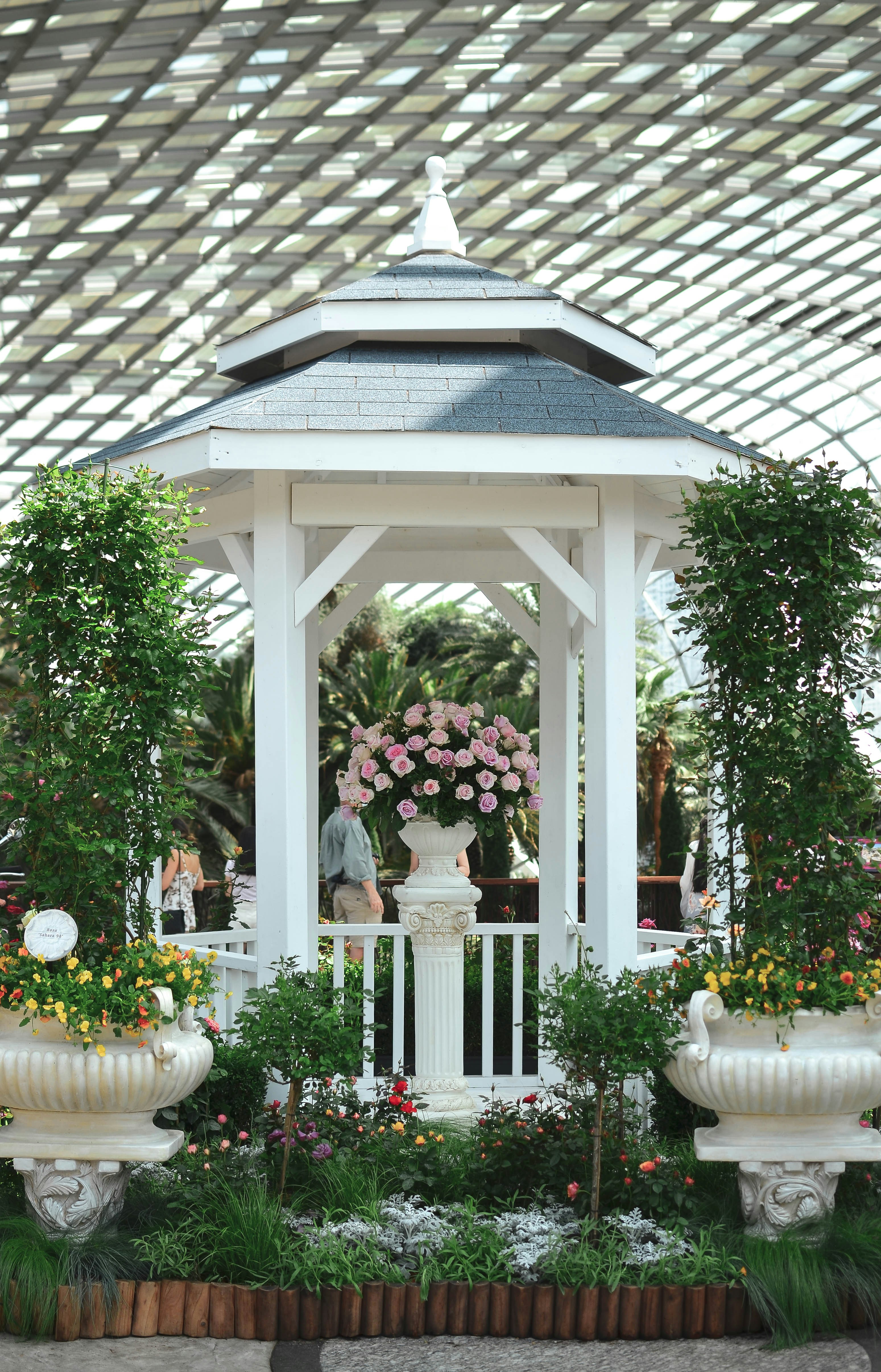 Pink Bouquet on a Pedestal Framed by a Sunlit White Gazebo