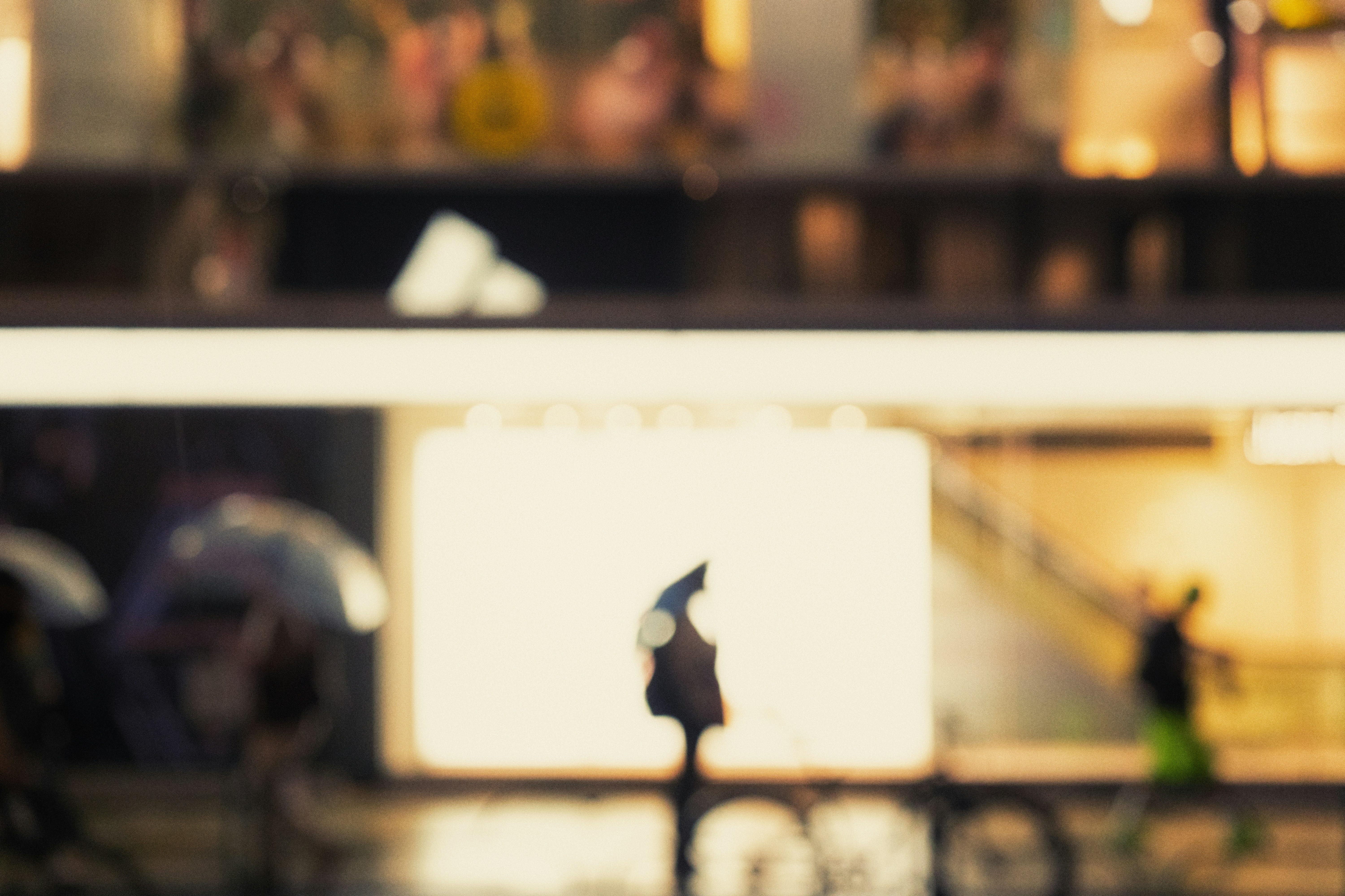 Neon Quiet: Umbrella Silhouette Across a Blurred Cityfront