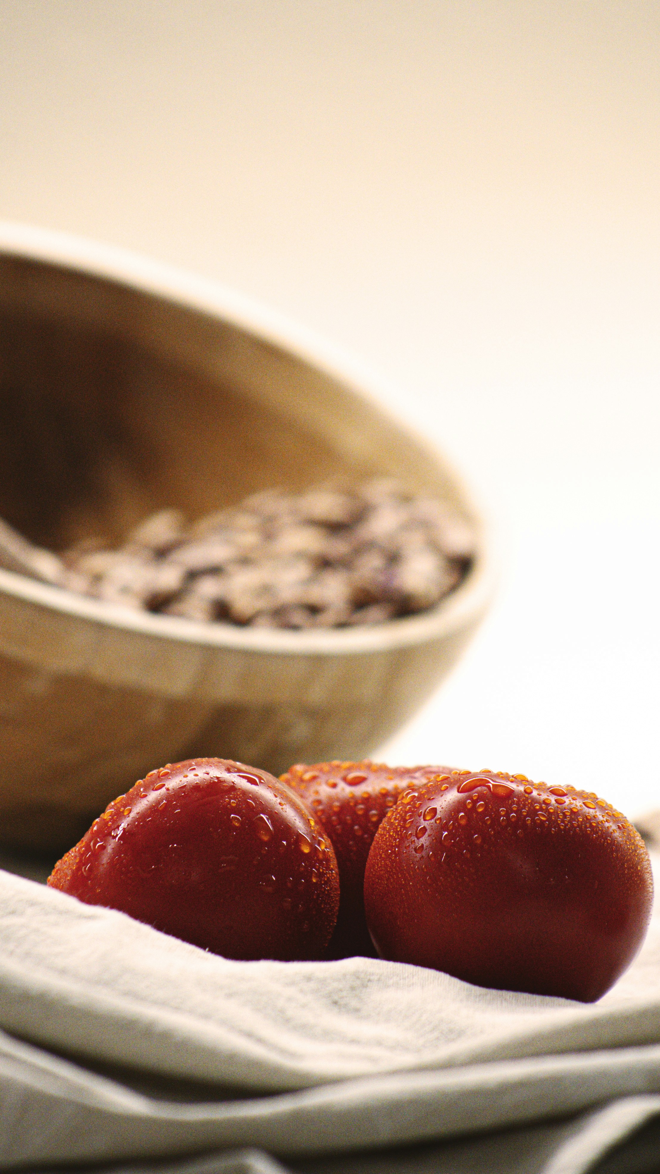 Juxtaposed sweetness: cherries rest beside a wooden grain bowl
