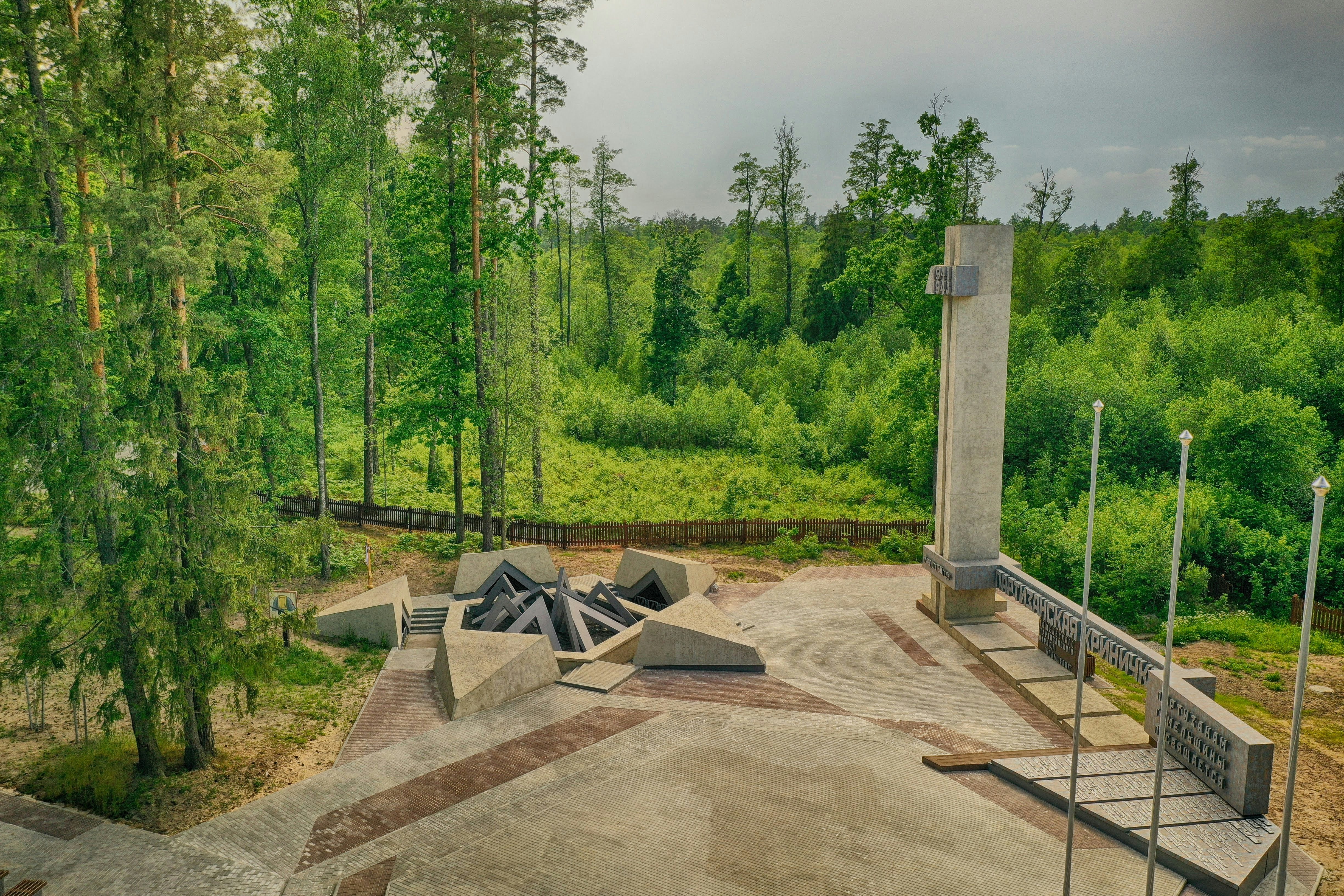 Obelisk Over Pine Veil: Concrete Geometry in a Quiet Plaza