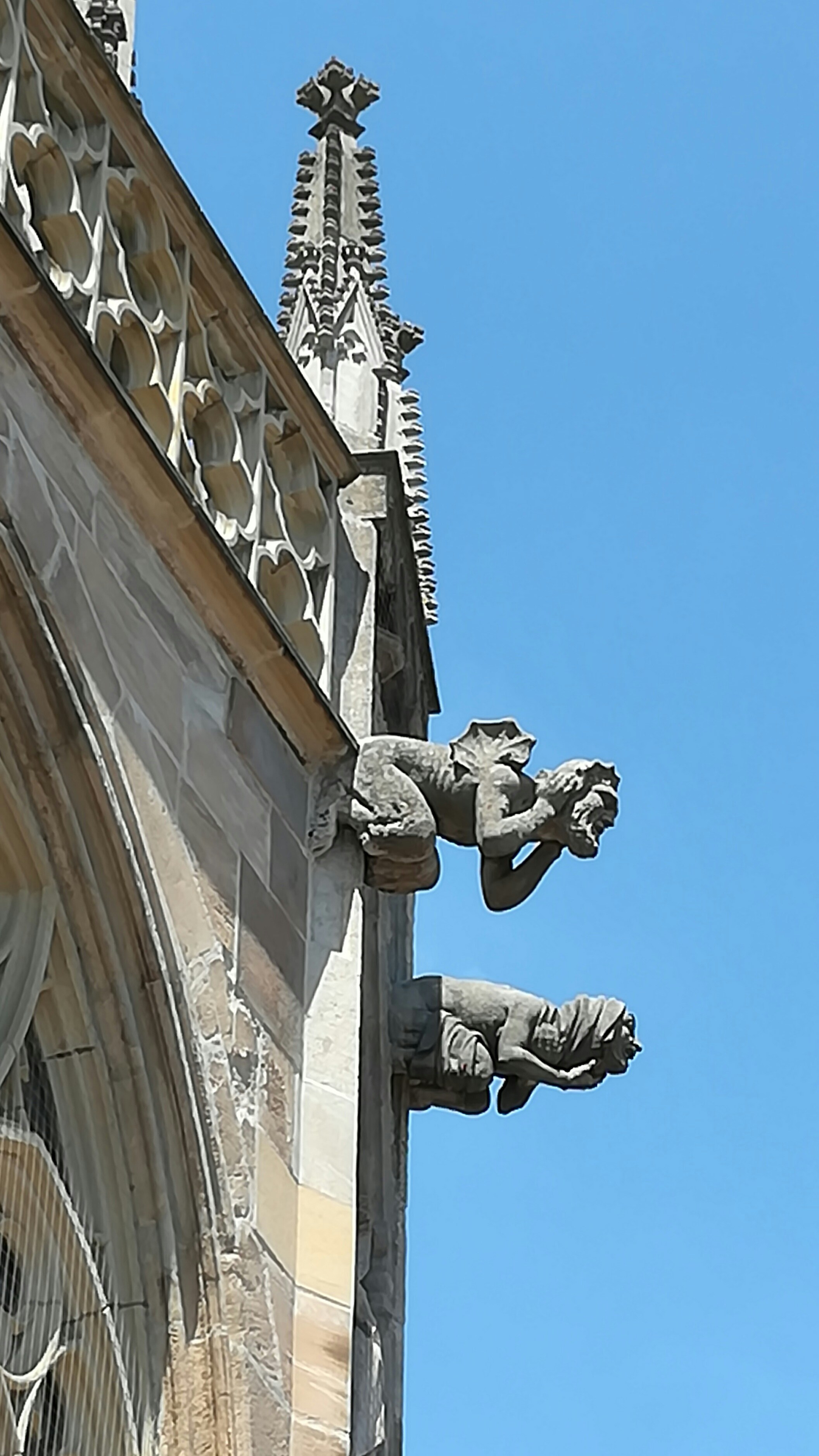 Gothic Gargoyle Sentinel: Sunlit Carved Guardian on Blue Sky