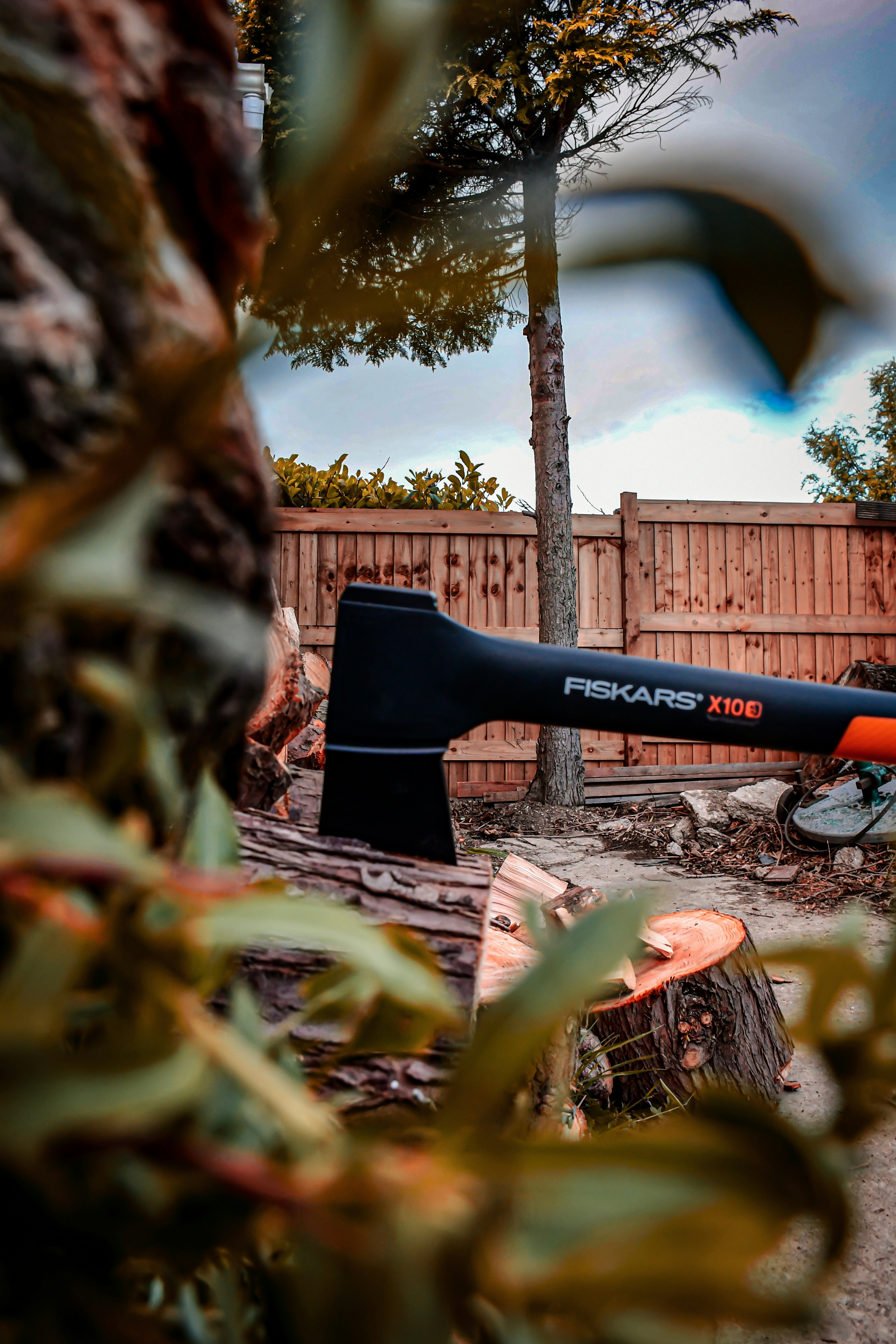 Axe in Focus: Backyard Worksite Framed by Overhanging Foliage