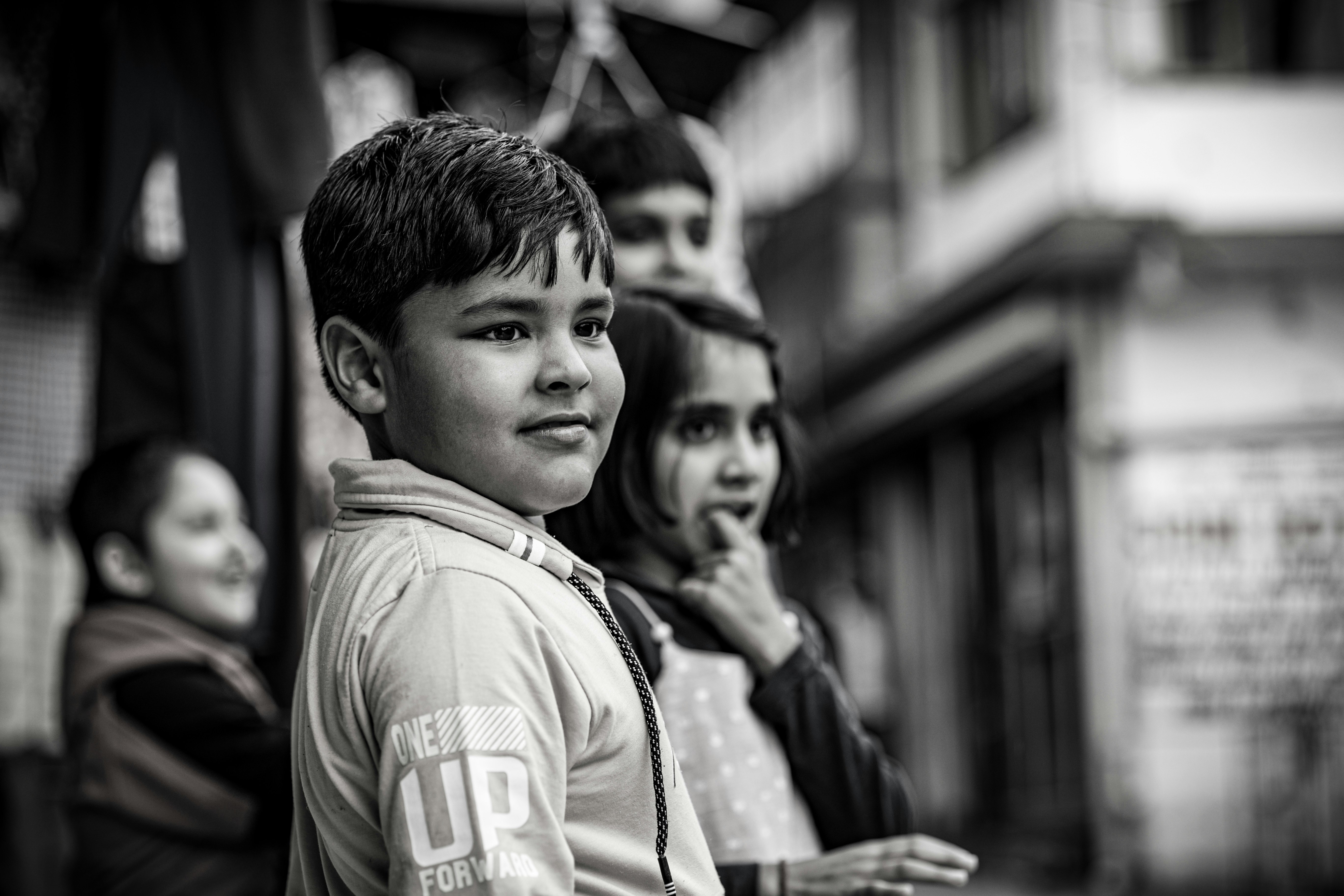 Front-Center Moment: A Boy in Focus Amid a Busy Street