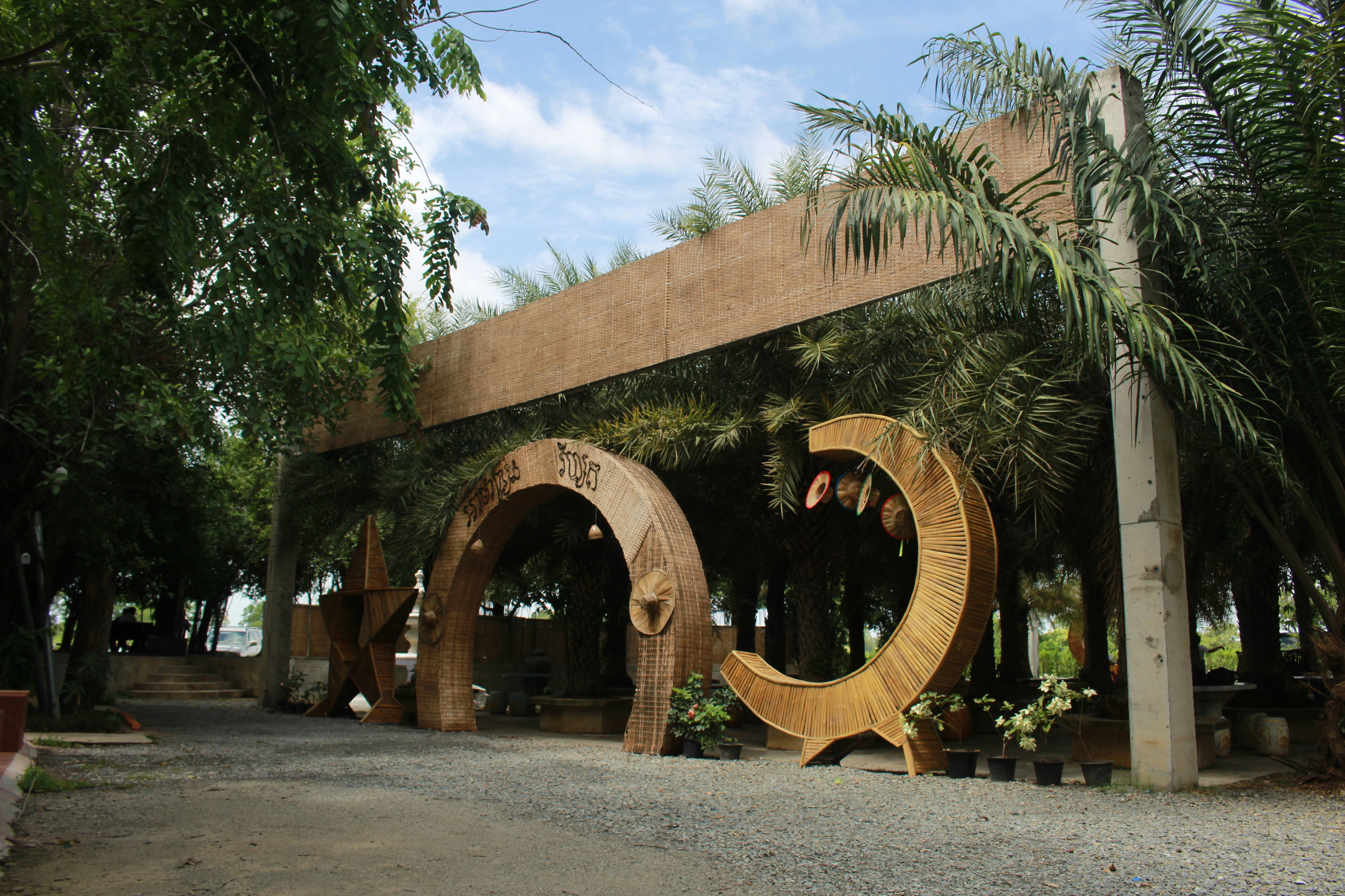 Timber Ring Sculptures Framed by Palms in a Quiet Courtyard