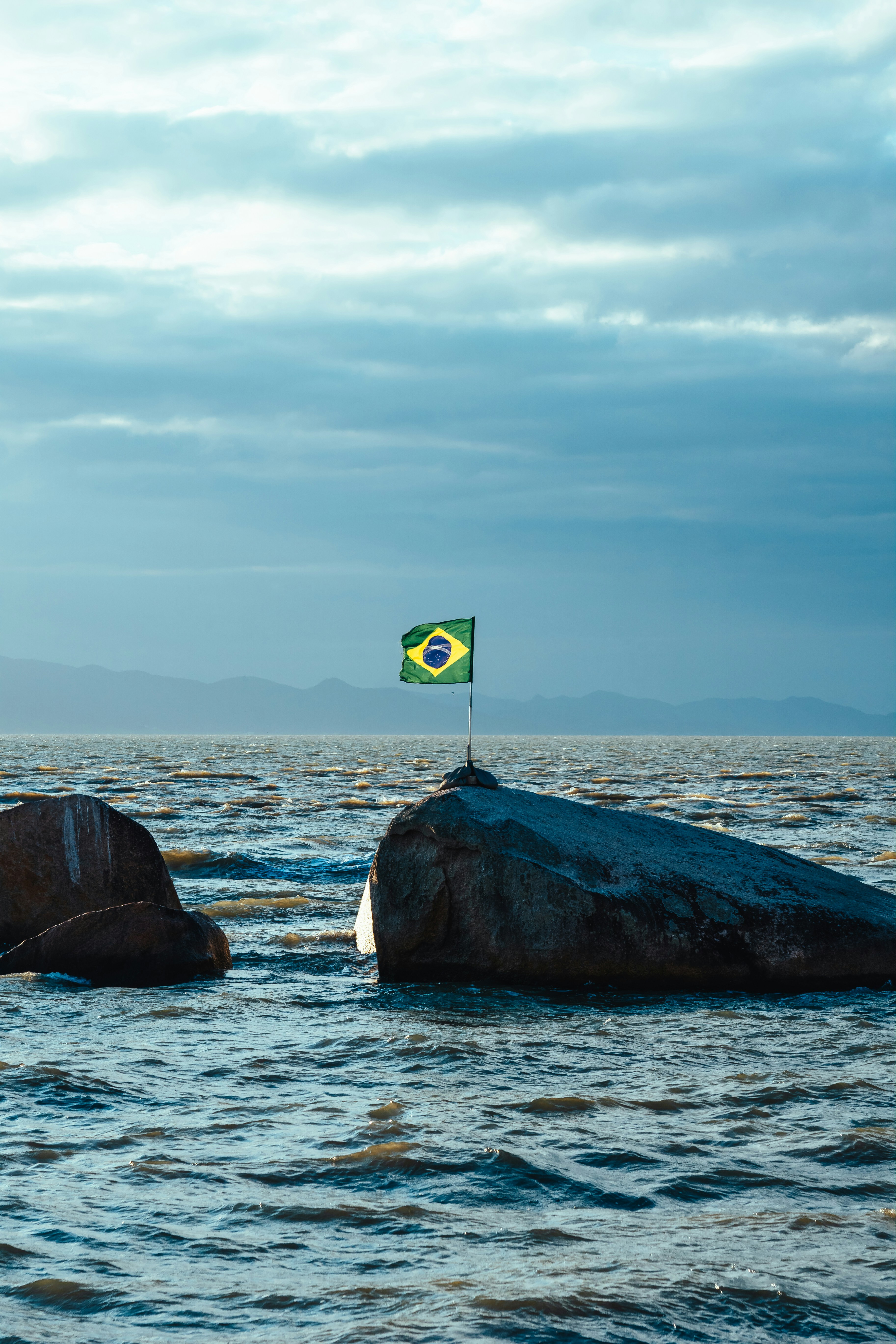 Una bandera en una roca en el agua foto – Imagen de Mar gratuita en ...