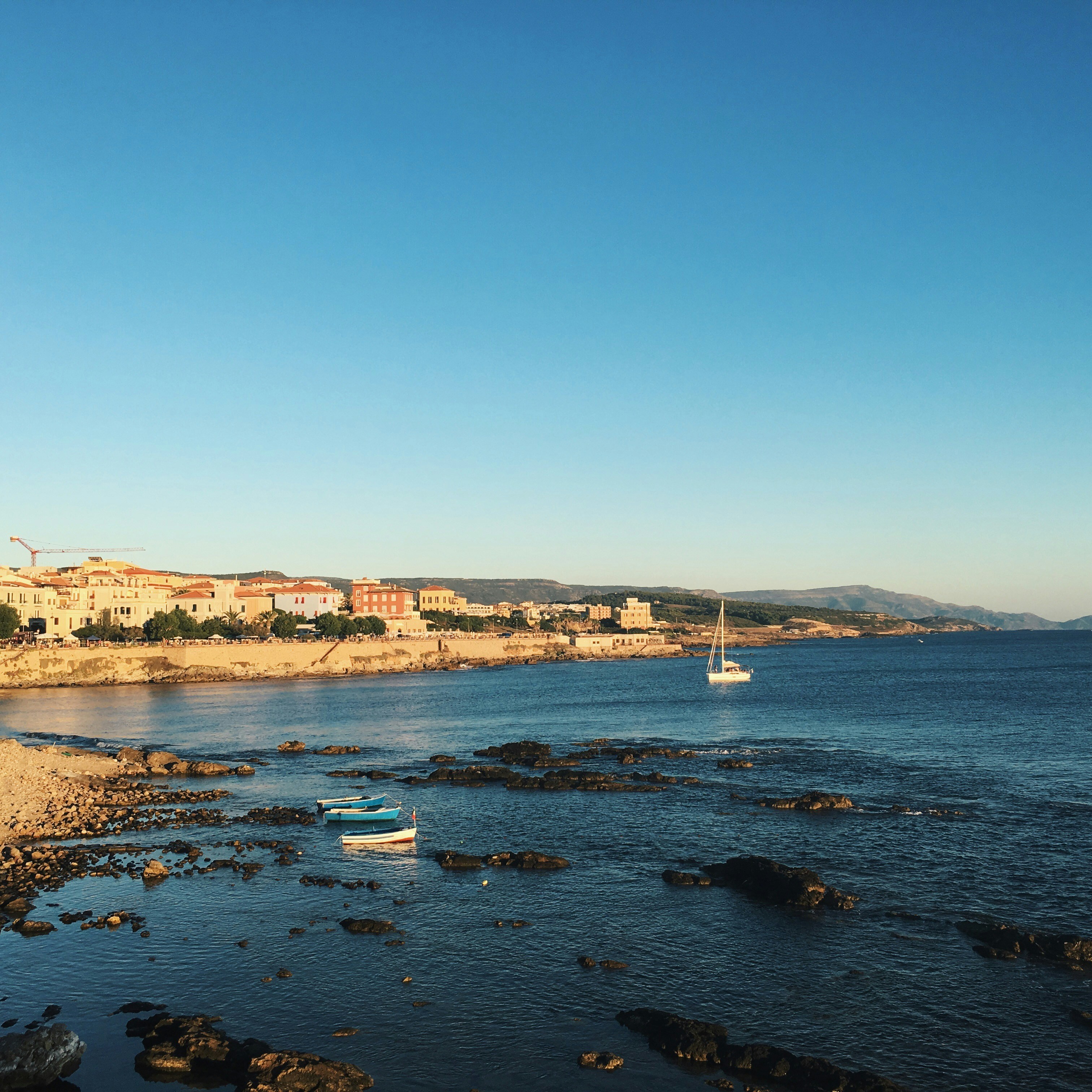 Coastal Town Horizon with Sloop under Clear Sky