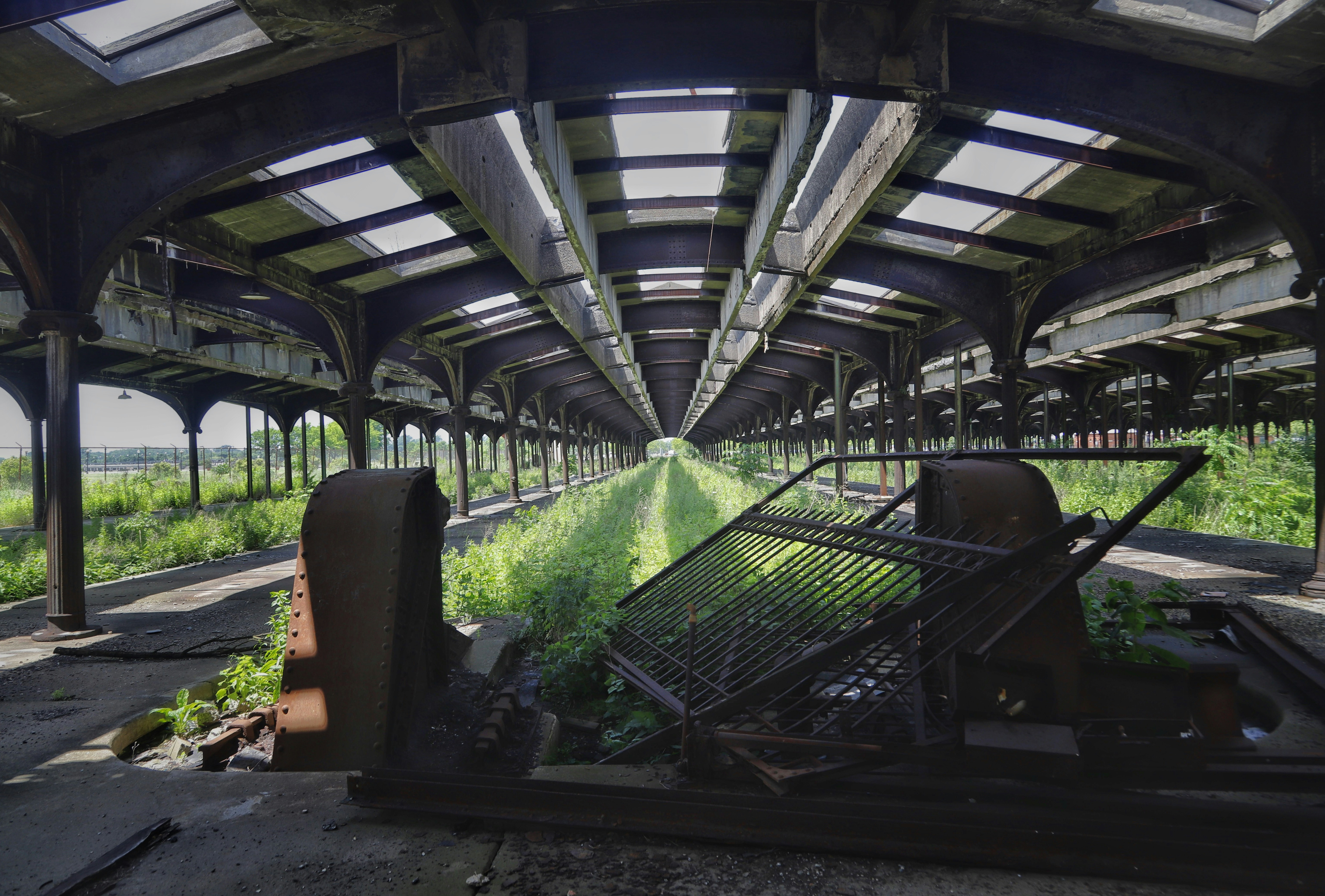 Vanishing Corridor: Steel Arches and Green Reclamation in an Abandoned Industrial Atrium