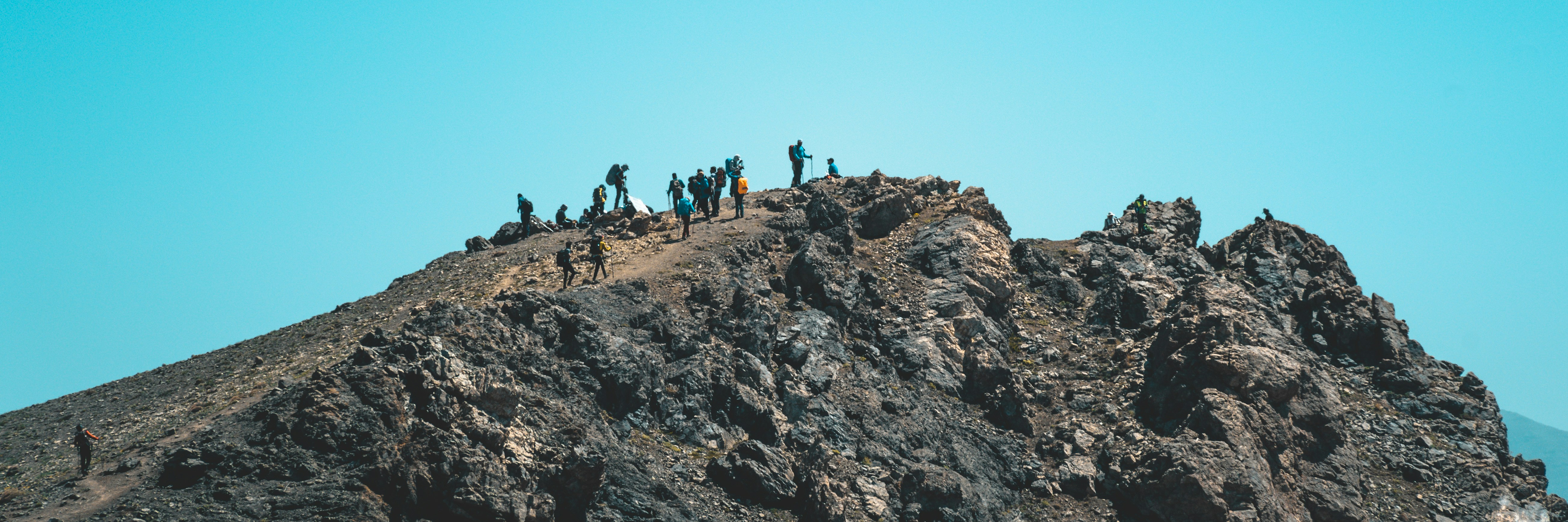 Ridge Summit: Climbers Trail the Jagged Volcanic Crest Under a Cobalt Sky