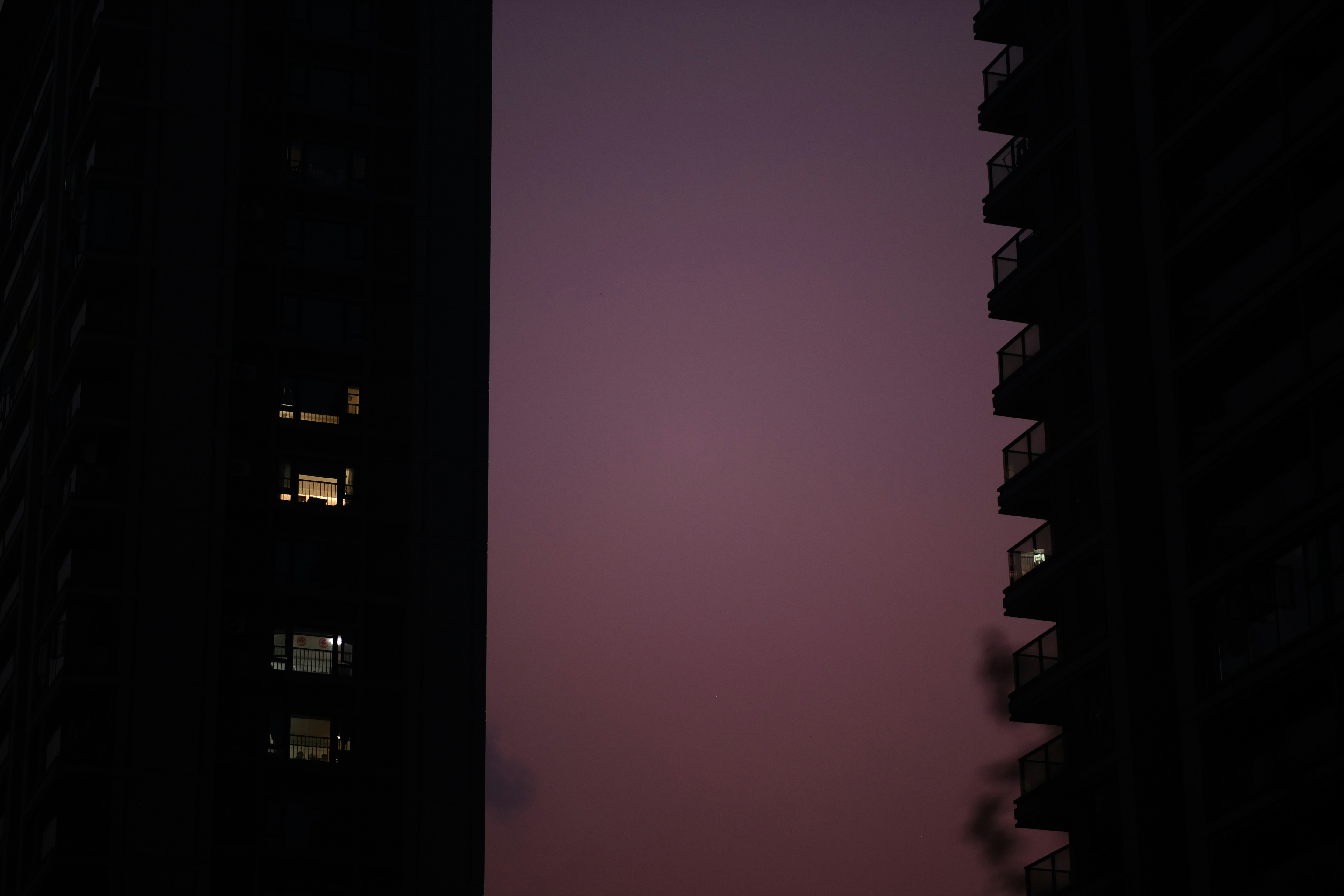 City in dusk | a tall building with a pink sky