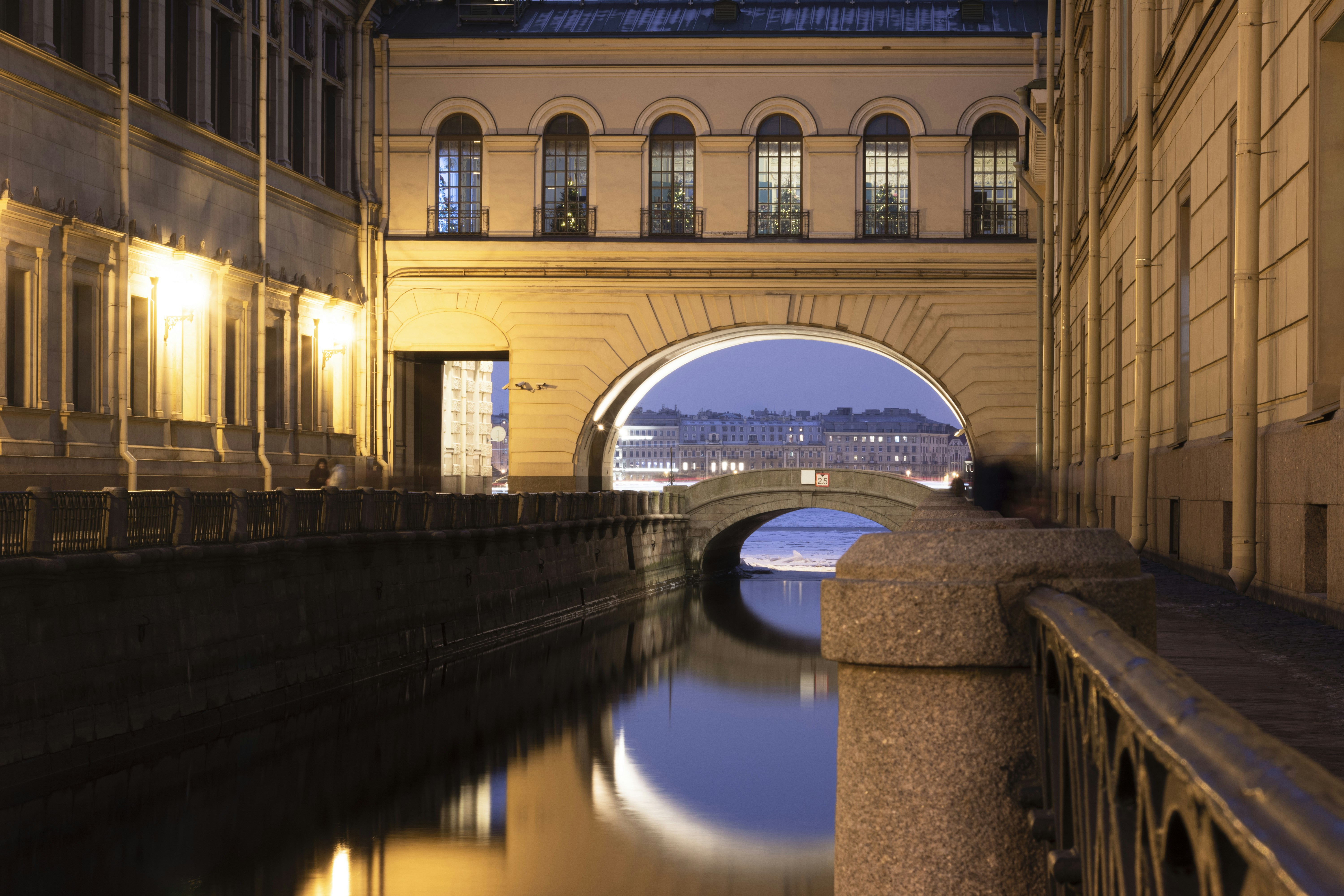 Archway at Dusk: Warm Reflections Along a City Canal