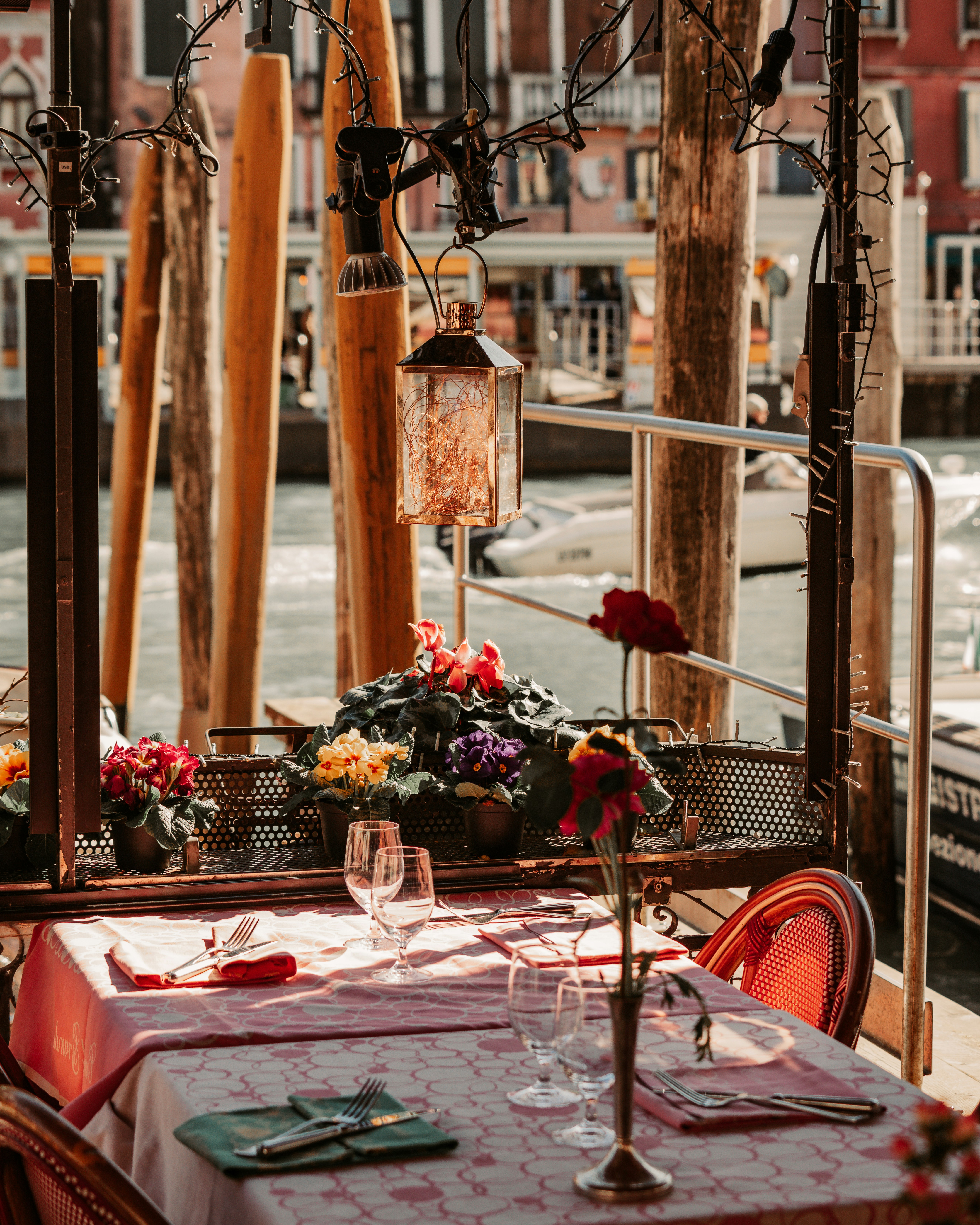 Sunlit Terrace Dinner Amid Lanterns and Boats