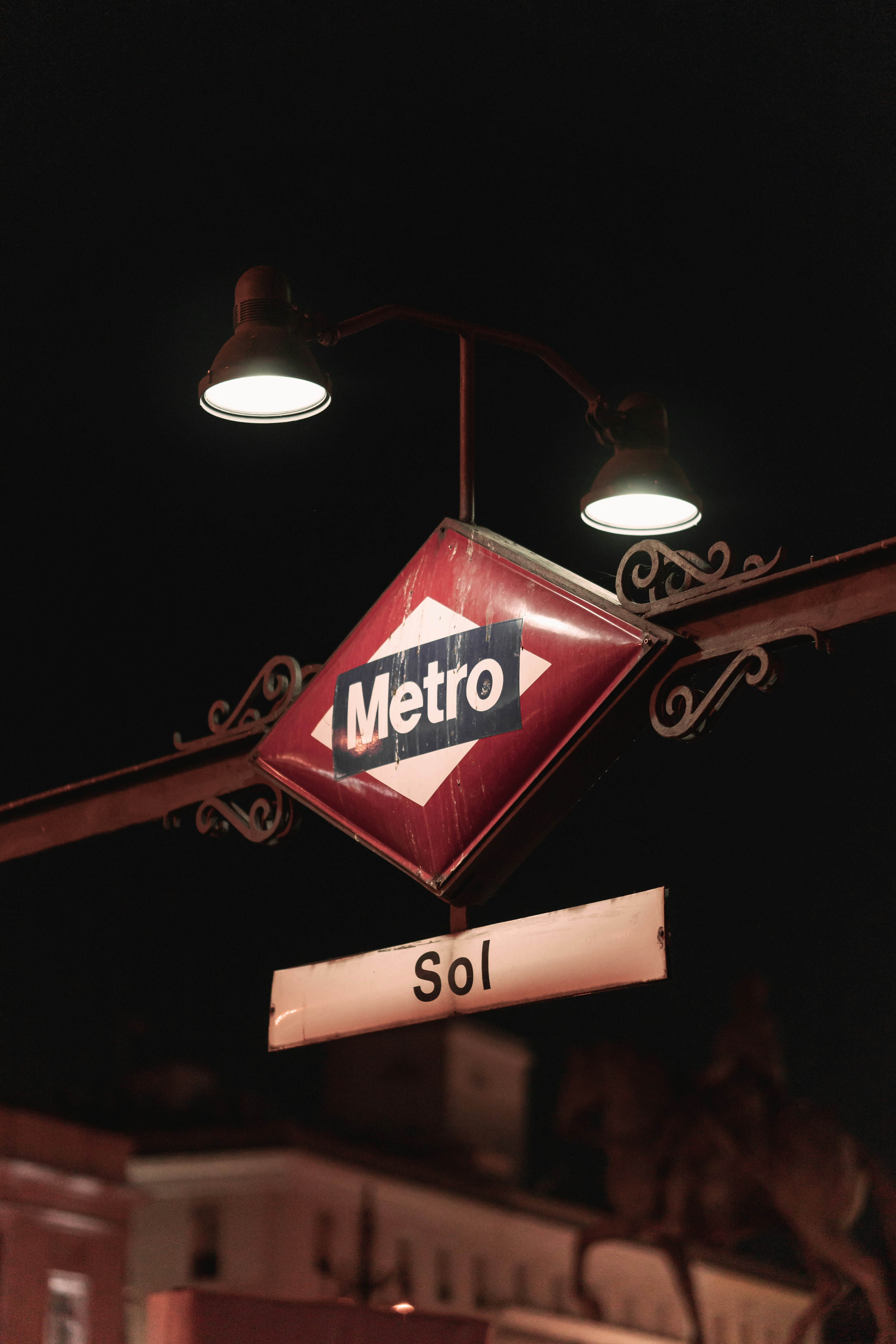 Illuminated Metro sign displaying 'Sol' against a dark backdrop, highlighting urban transit identity. The vintage design adds character to the night scene.