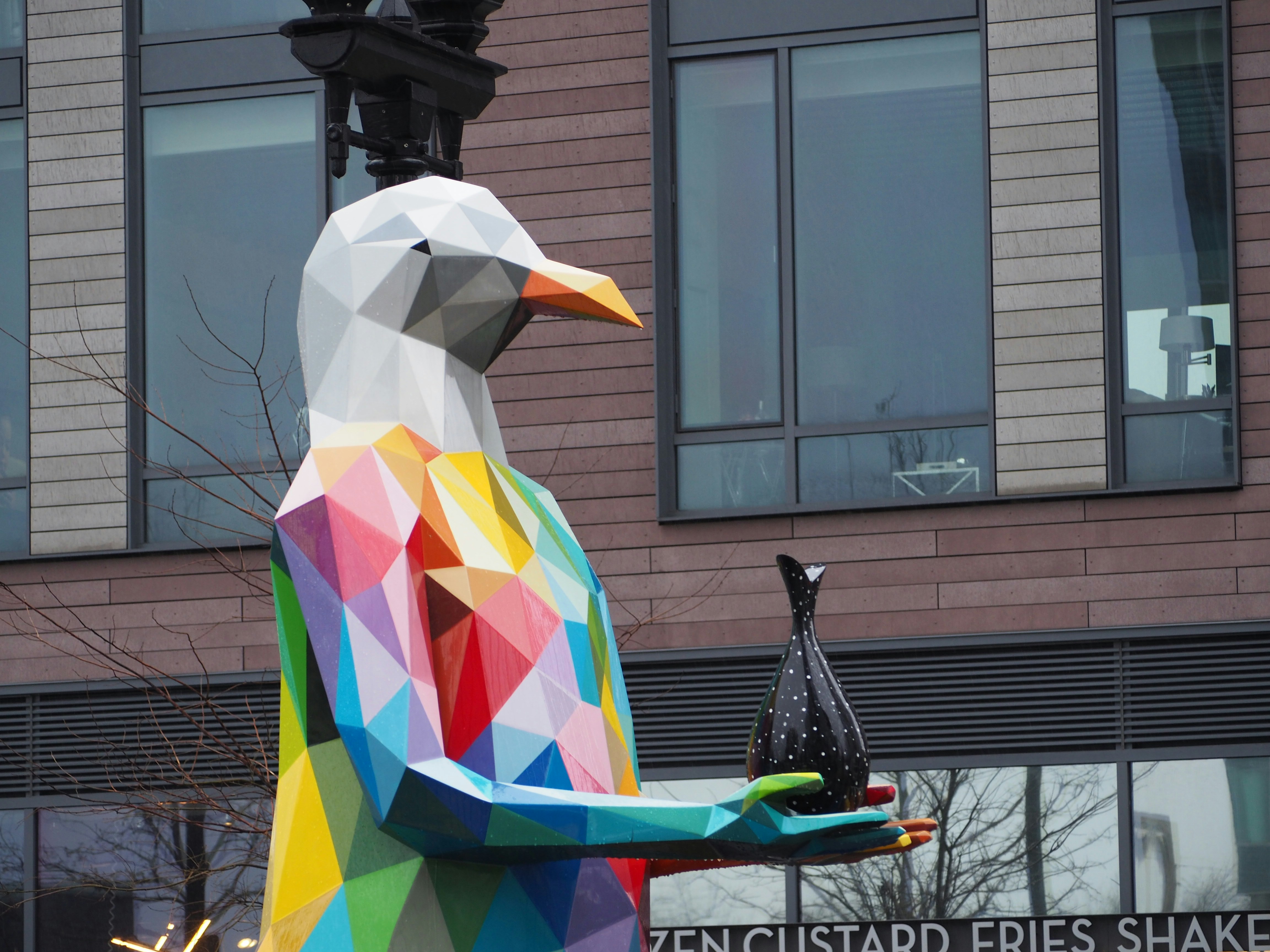 A colorful kite is flying in front of a building photo – Free Design ...
