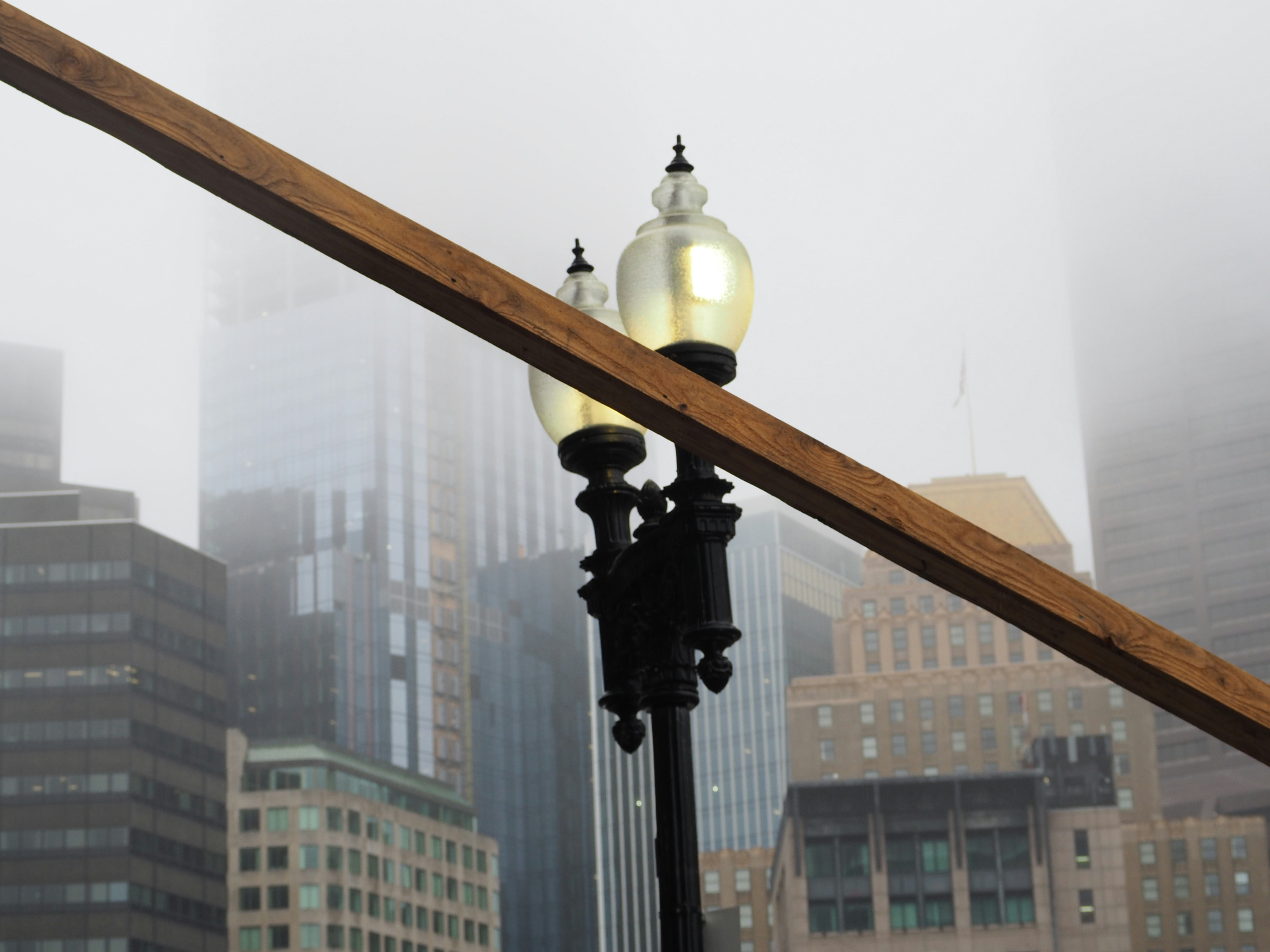 A lamp post with a city in the background photo – Free Usa Image on ...