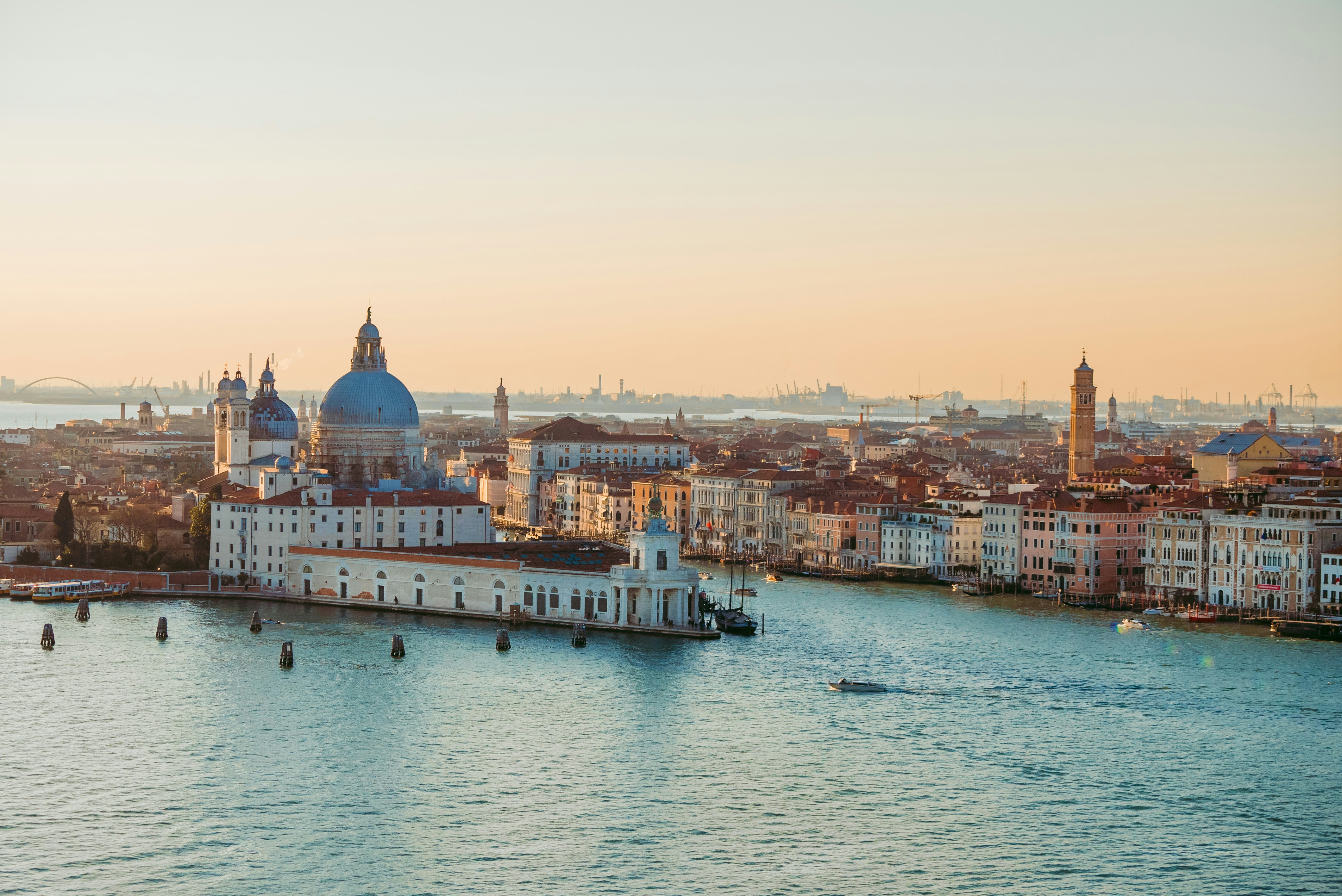 Venetian skyline with historic architecture and calm waters under a warm evening sky.
