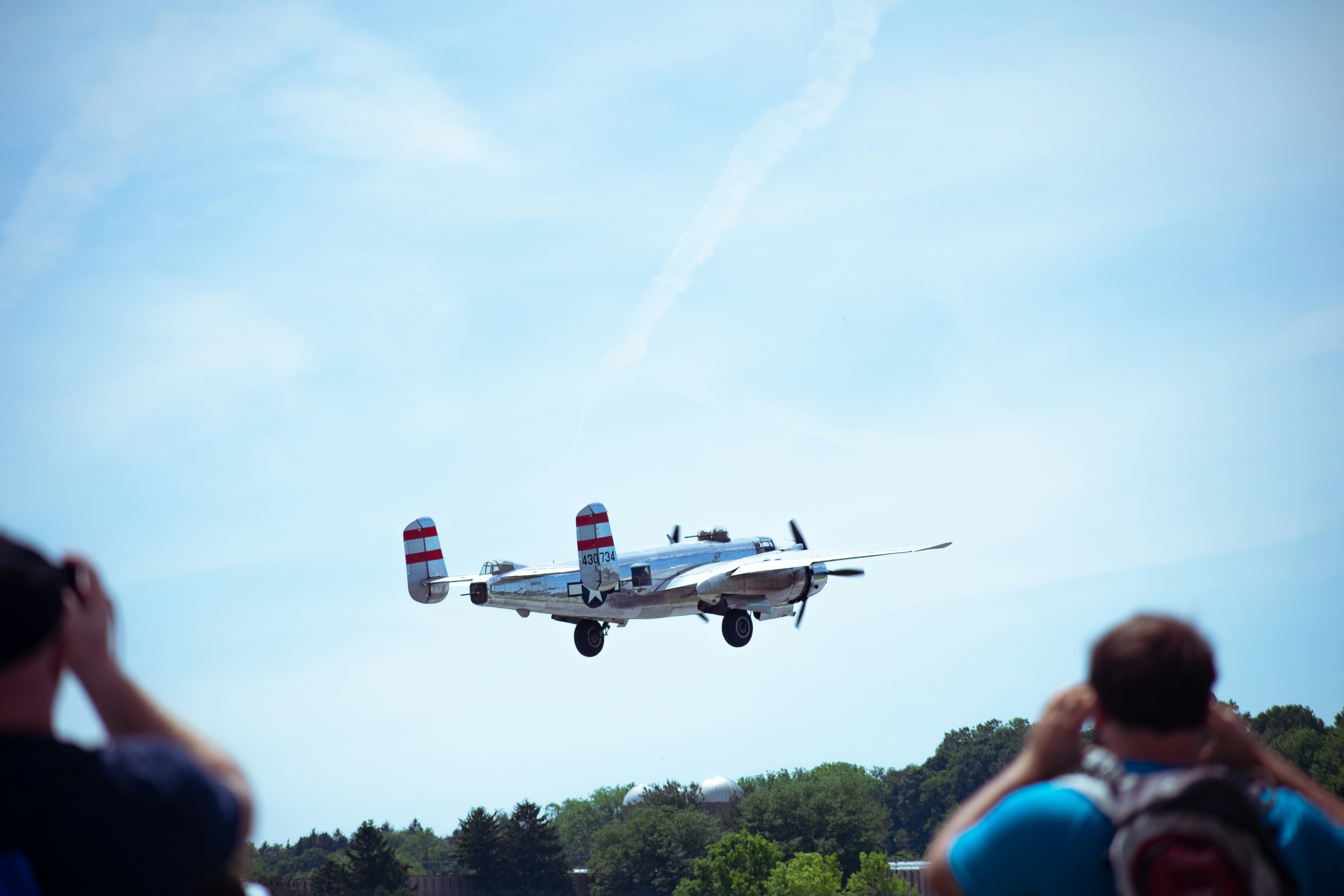 Skyward Echoes: A Vintage Twin-Prop Glides Over a Watching Crowd
