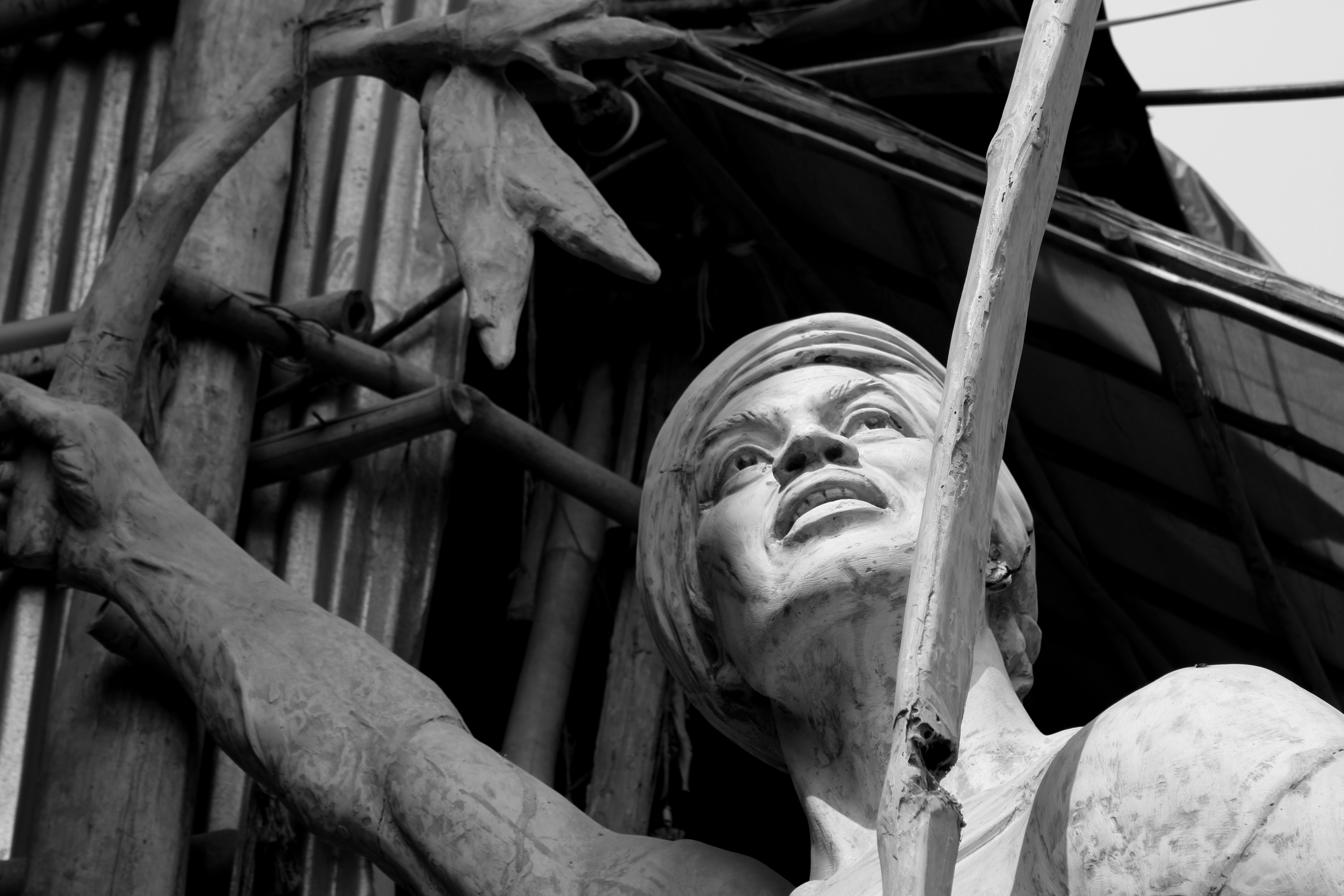 Gaze Between Scaffolds: A Weathered Statue Under Construction