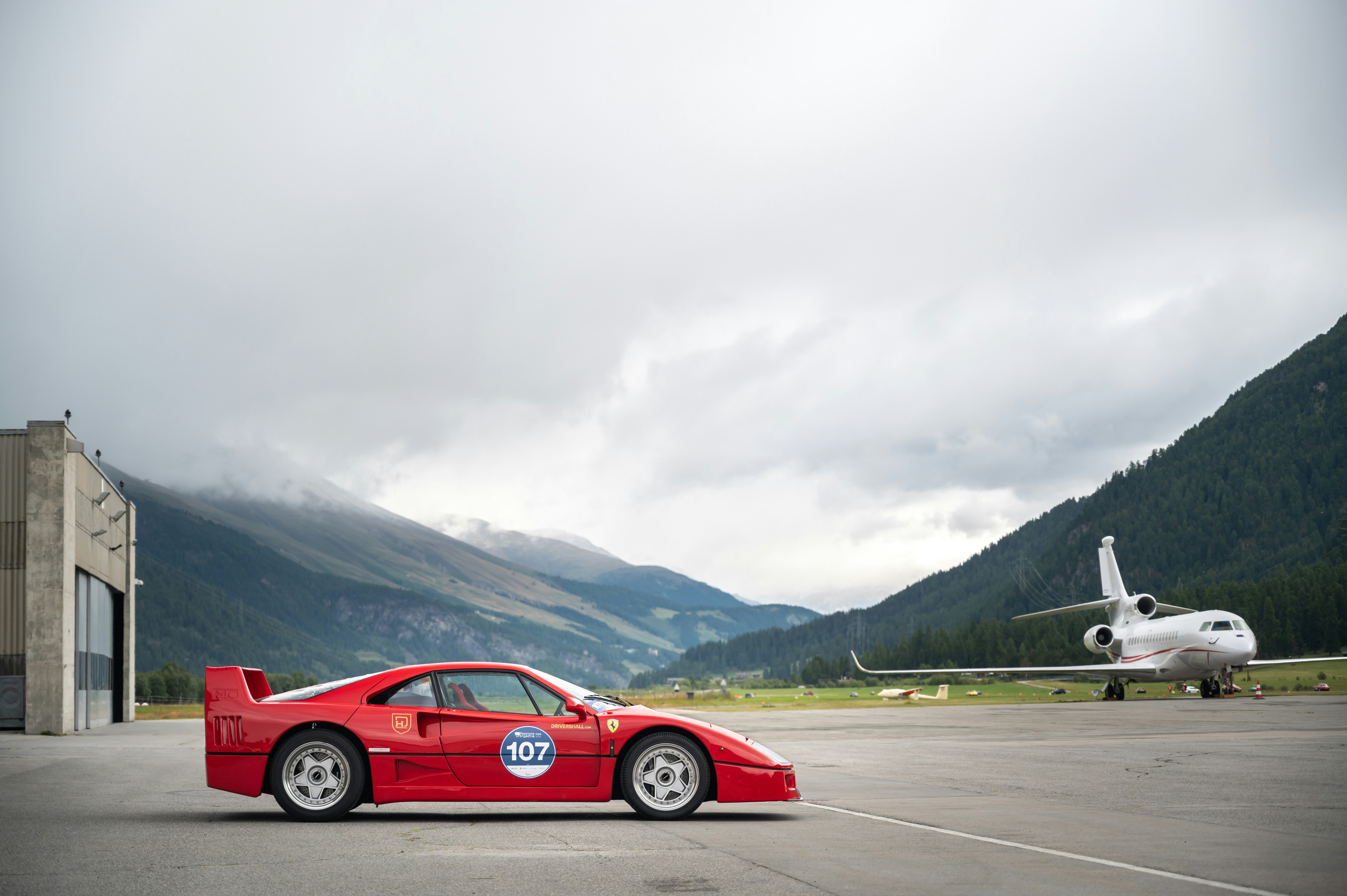 Red Ferrari on a Quiet Tarmac with Alpine backdrop