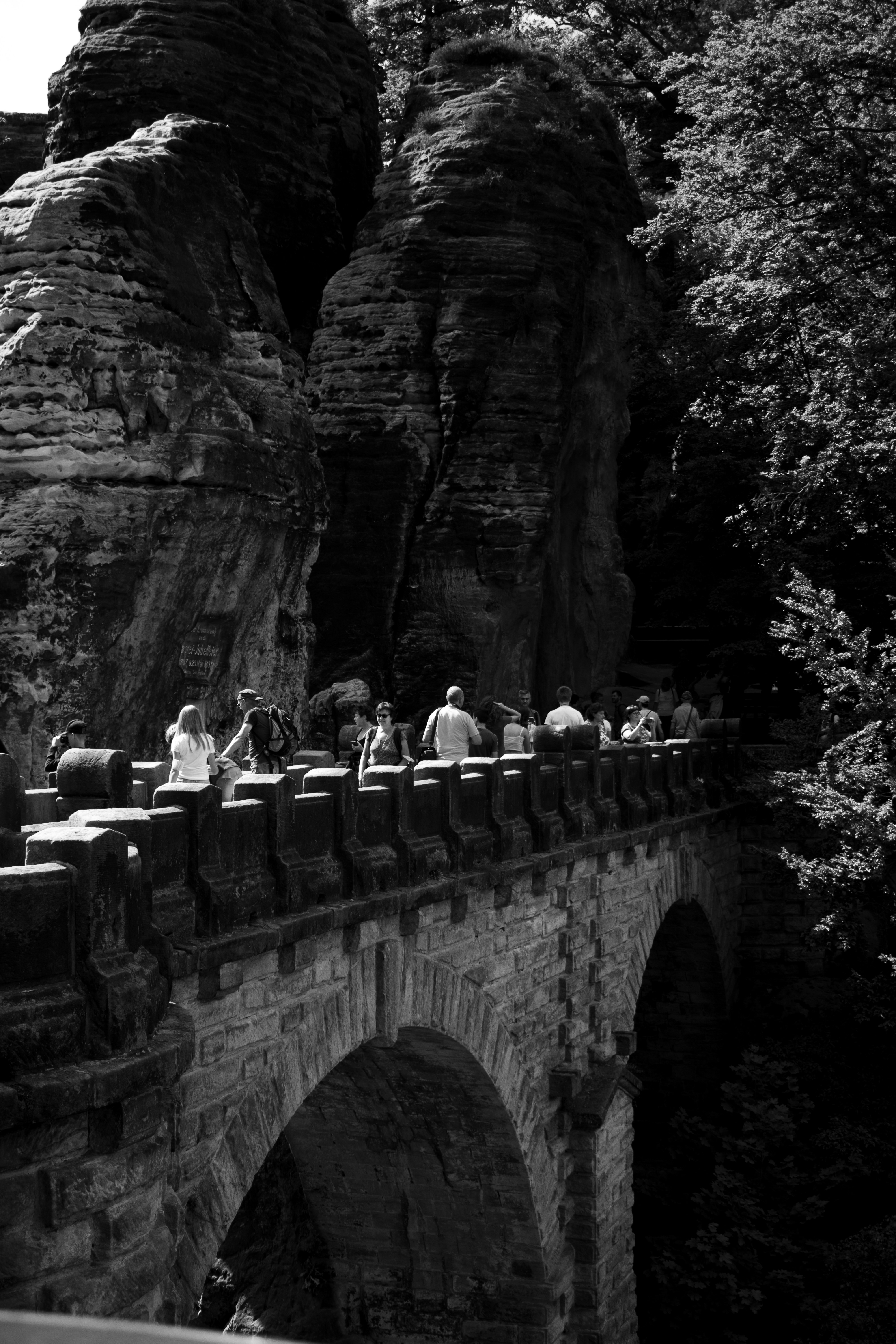 Stone Span and Spectators: A Black-and-White View Across the Bridge