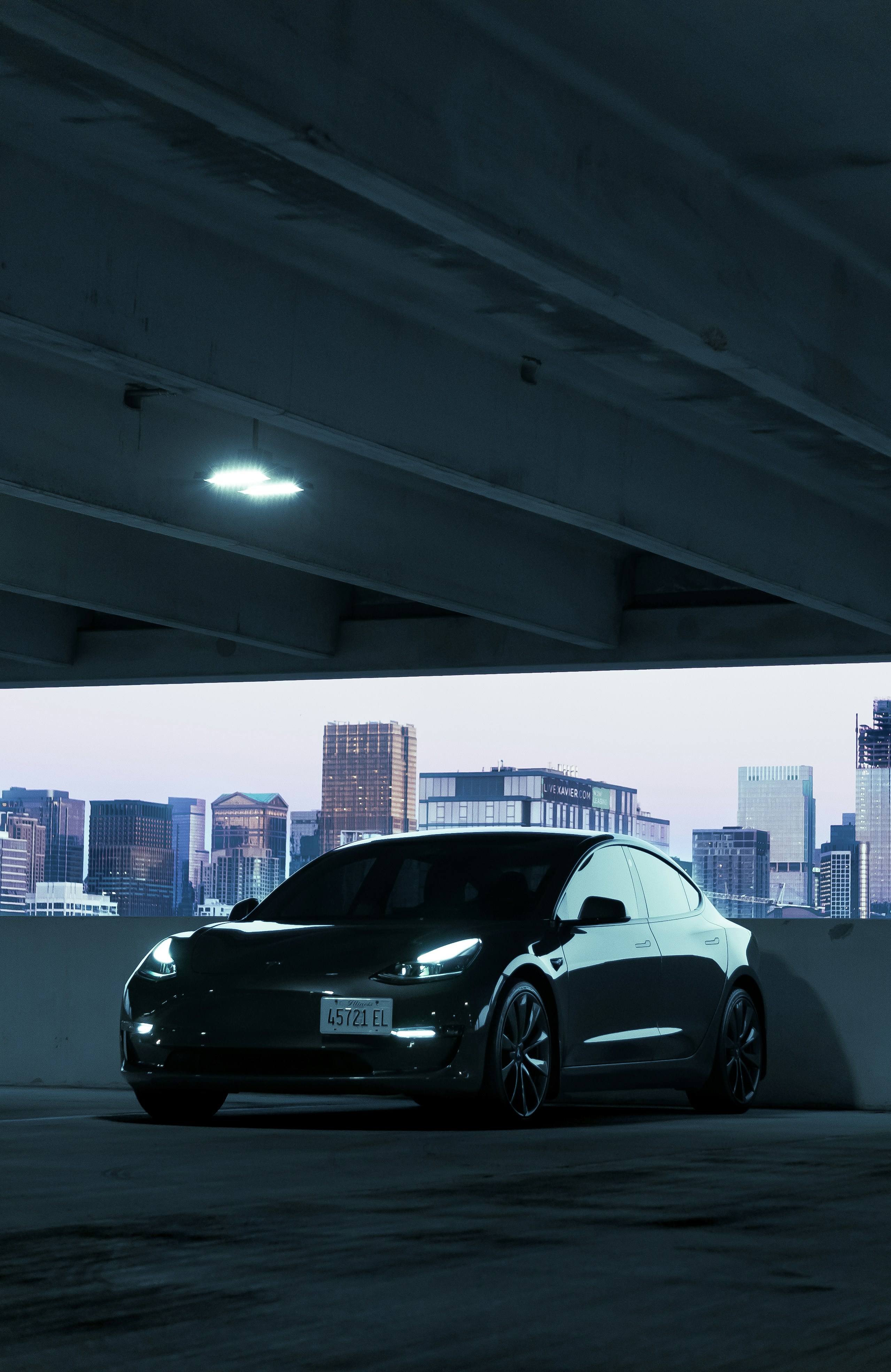 A black car parked under a bridge photo – Free Blue Image on Unsplash