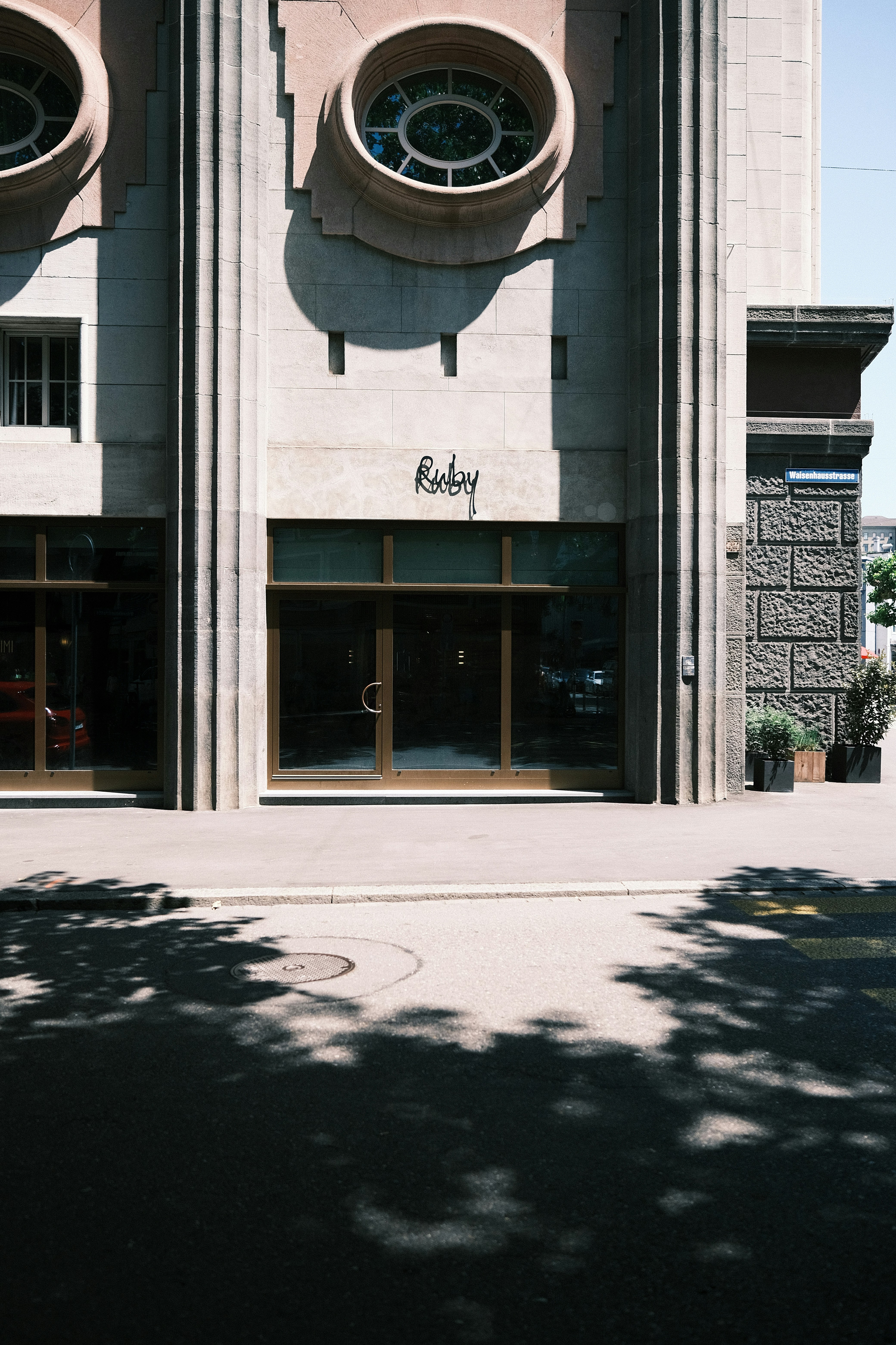 Ruby Above the Doors: Circular Windows Framing a Quiet Facade
