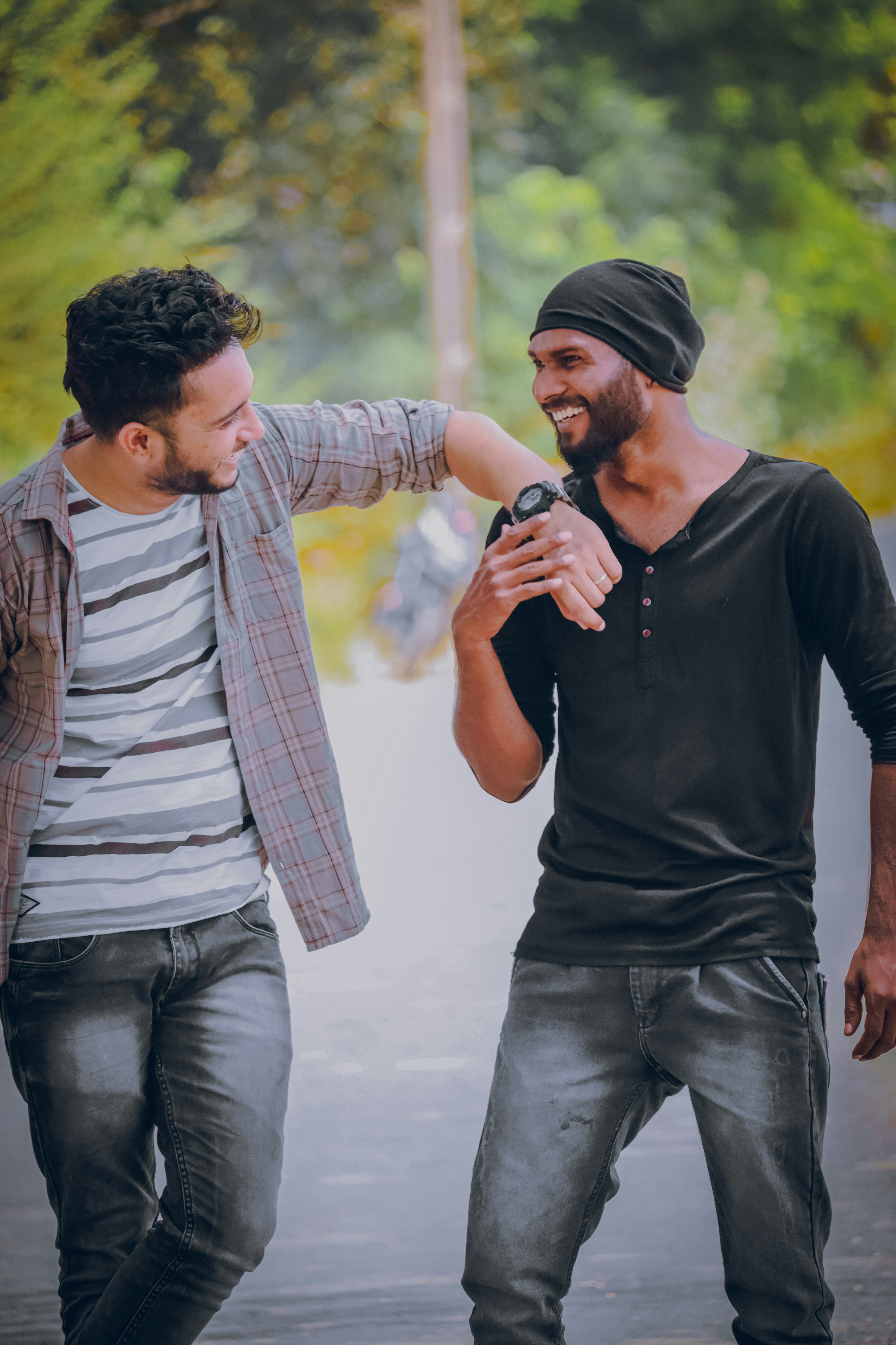 Sunlit Bond: Two Friends Share a Laugh on a Park Walk
