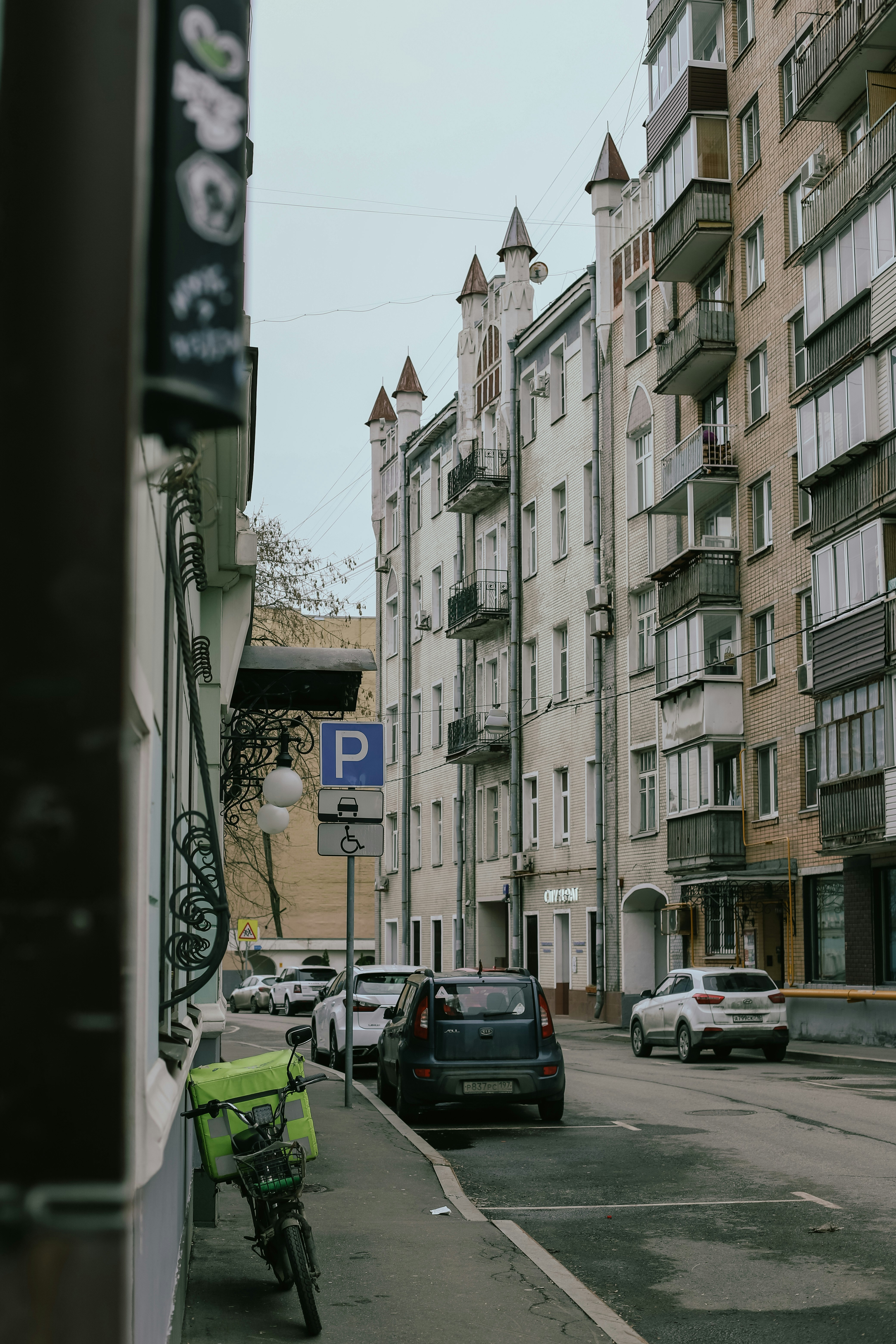 Urban Facade Arches: A Quiet Street Toward the Parking Sign