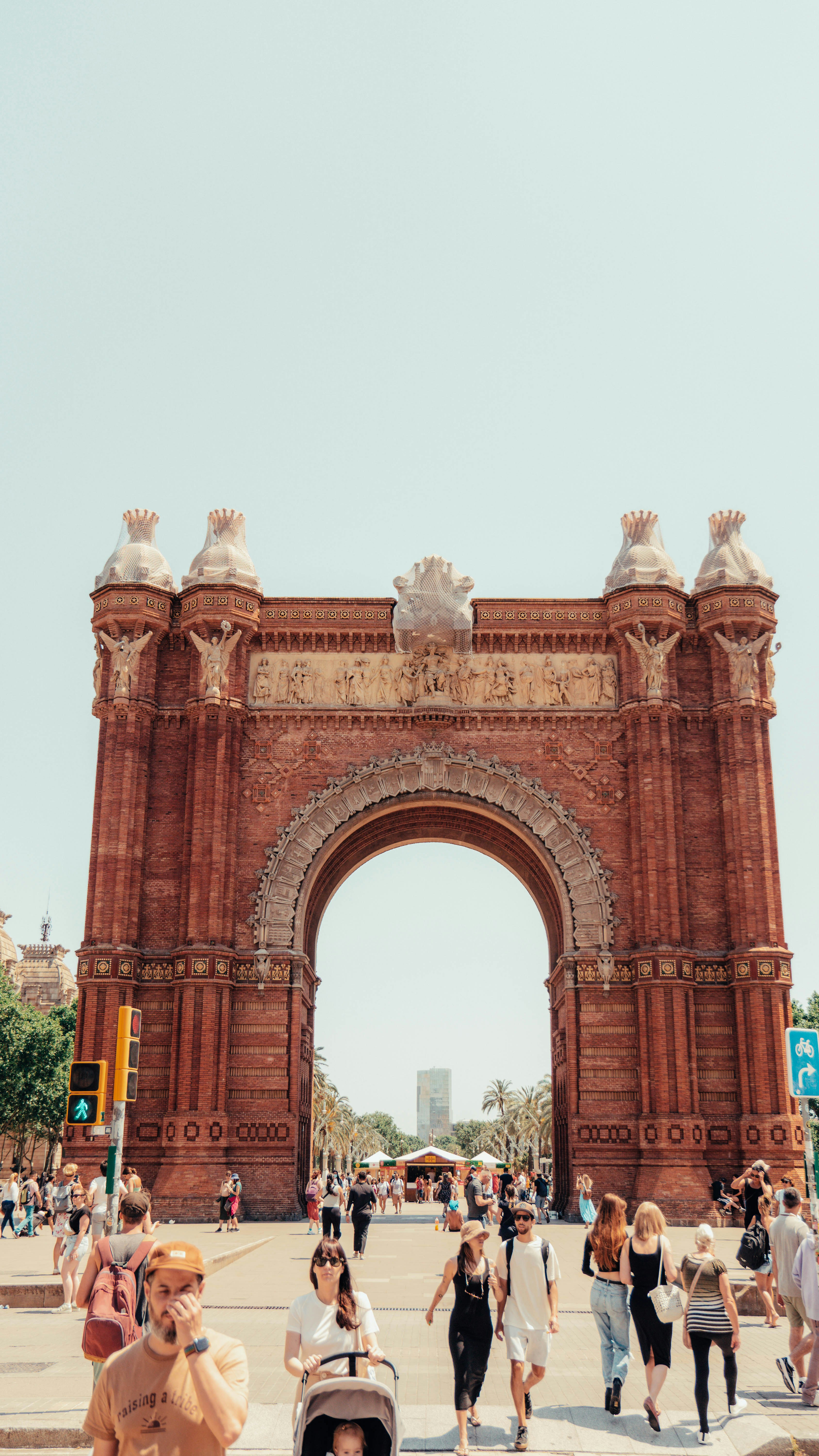Iconic archway adorned with intricate sculptures, bustling with pedestrians and vibrant city life.