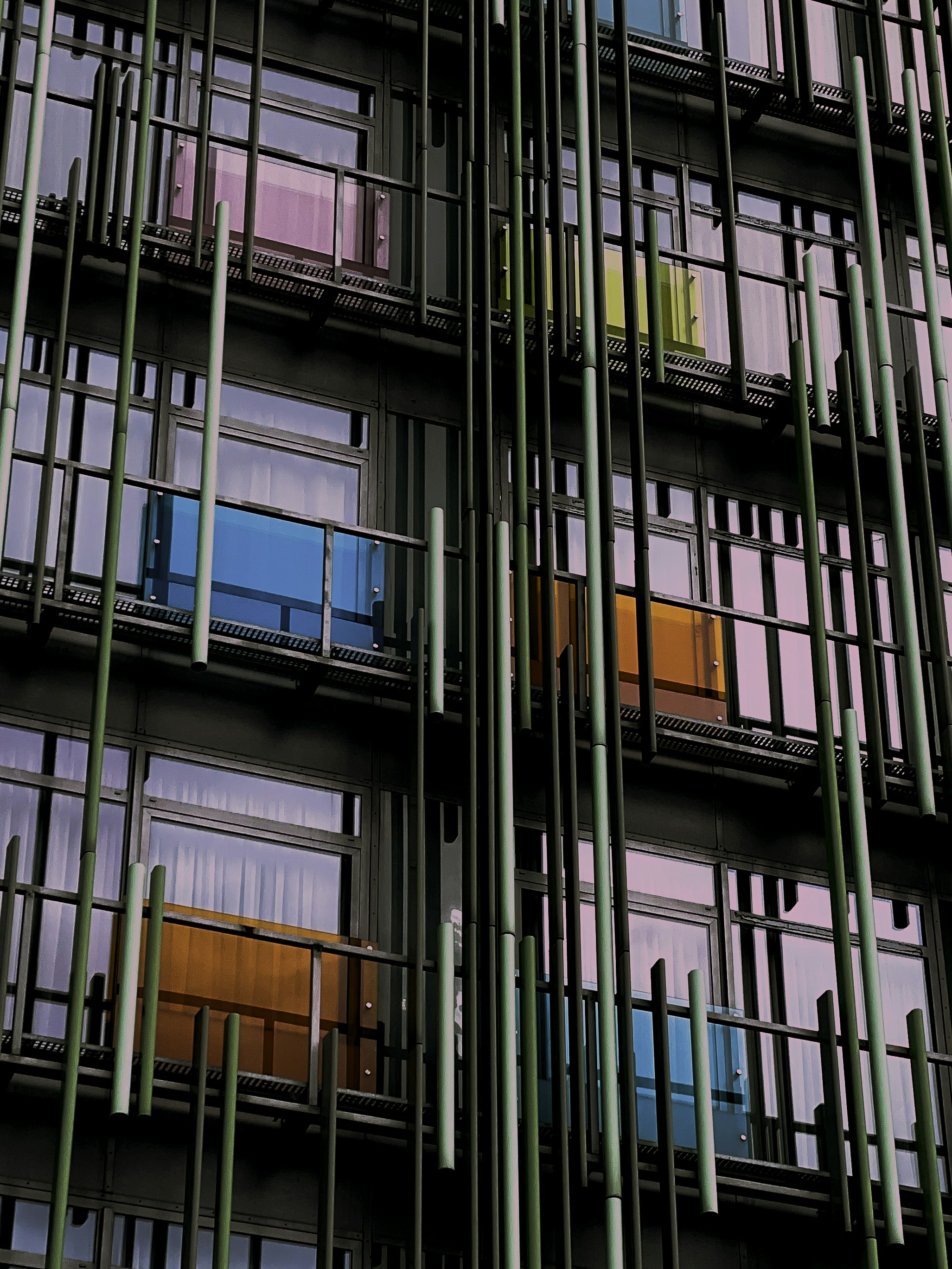 Colorful balconies juxtaposed against a modern architectural facade, highlighting the interplay of light and shadow.