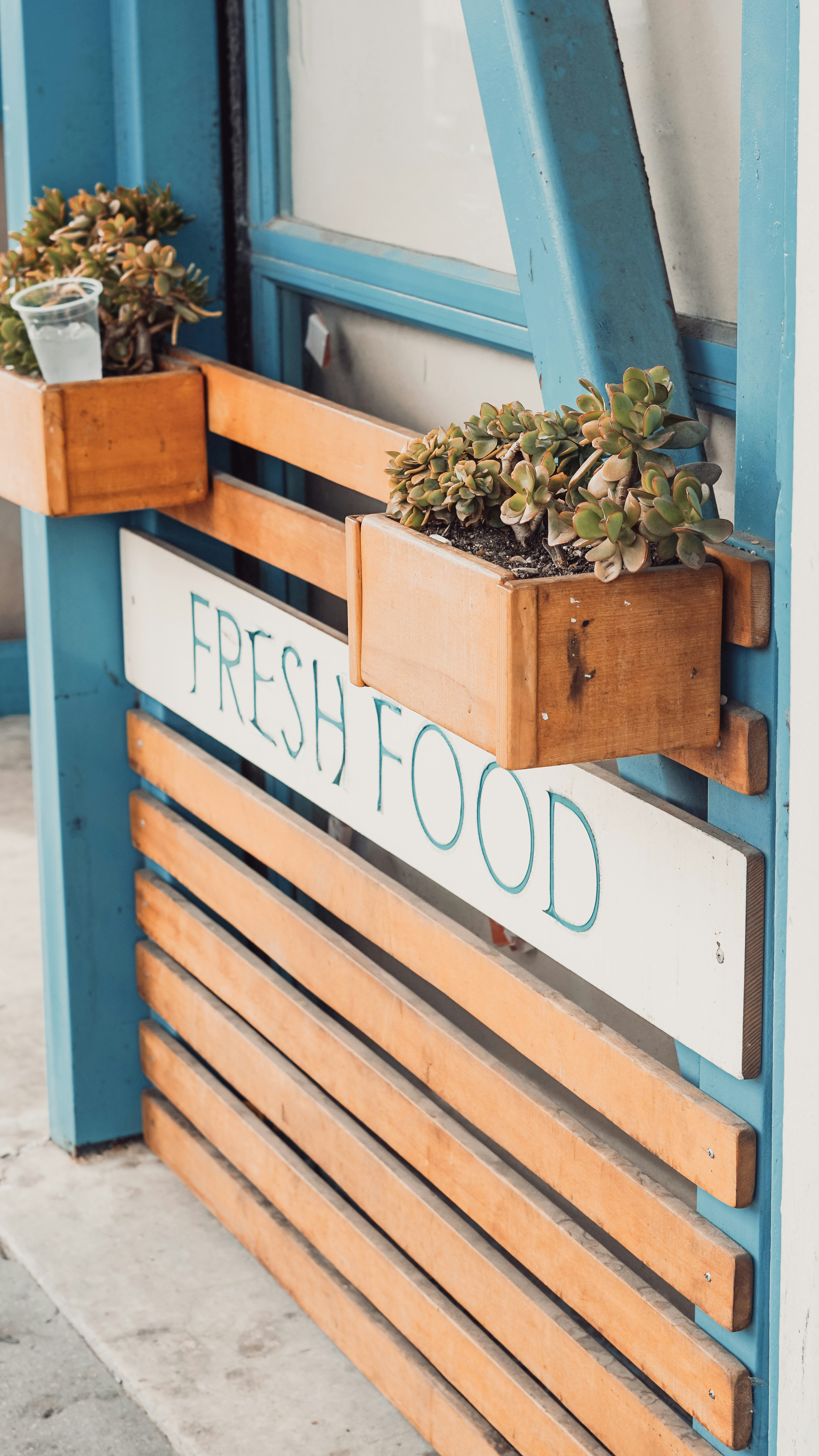Fresh Food Framed in Blue: Planters on a Sunlit Storefront