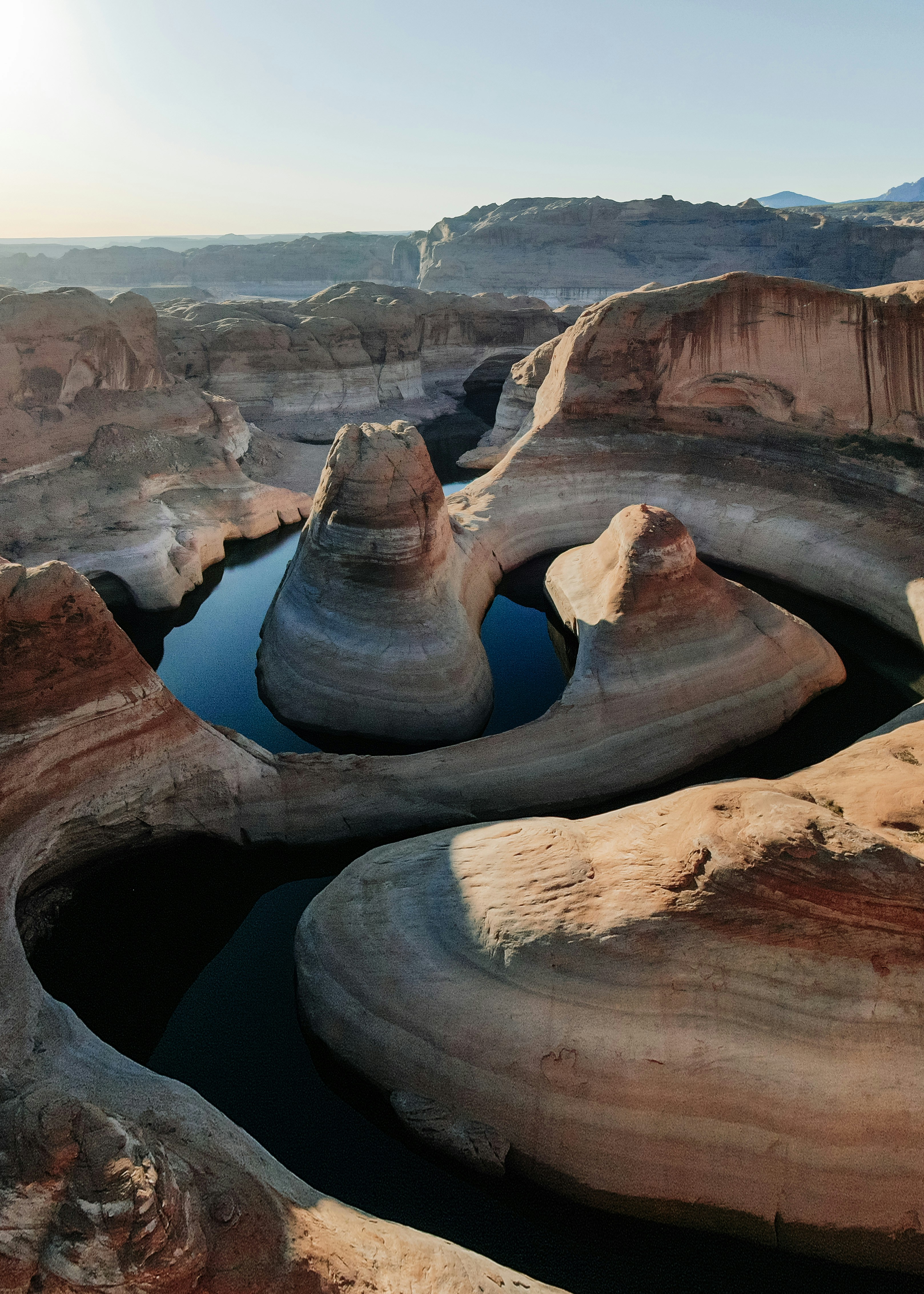 Aerial view of unique rock formations surrounded by tranquil waters, showcasing the intricate patterns carved by nature over time.