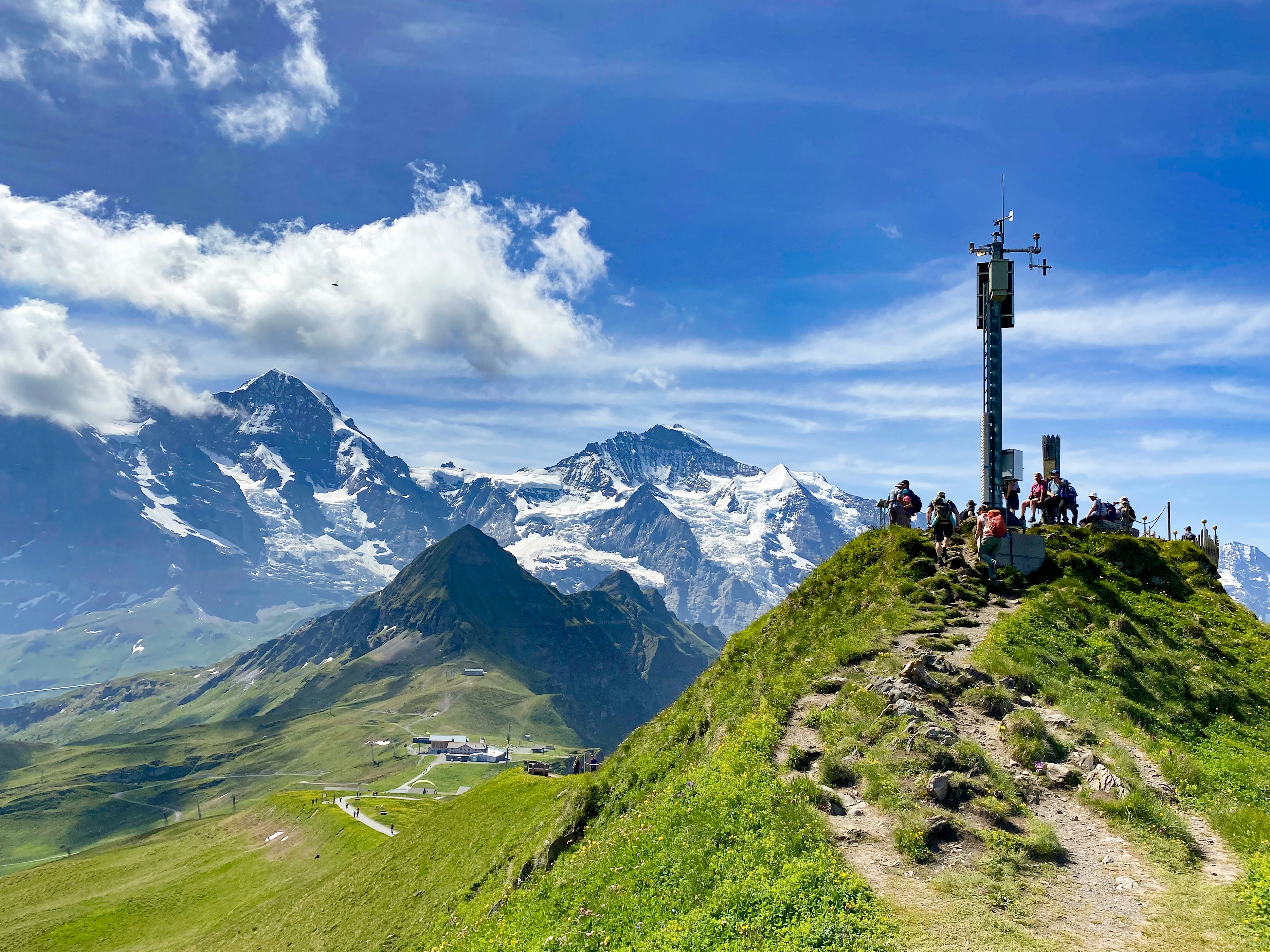 Alpine Crest Convergence: Summit Crowd and Weather Mast
