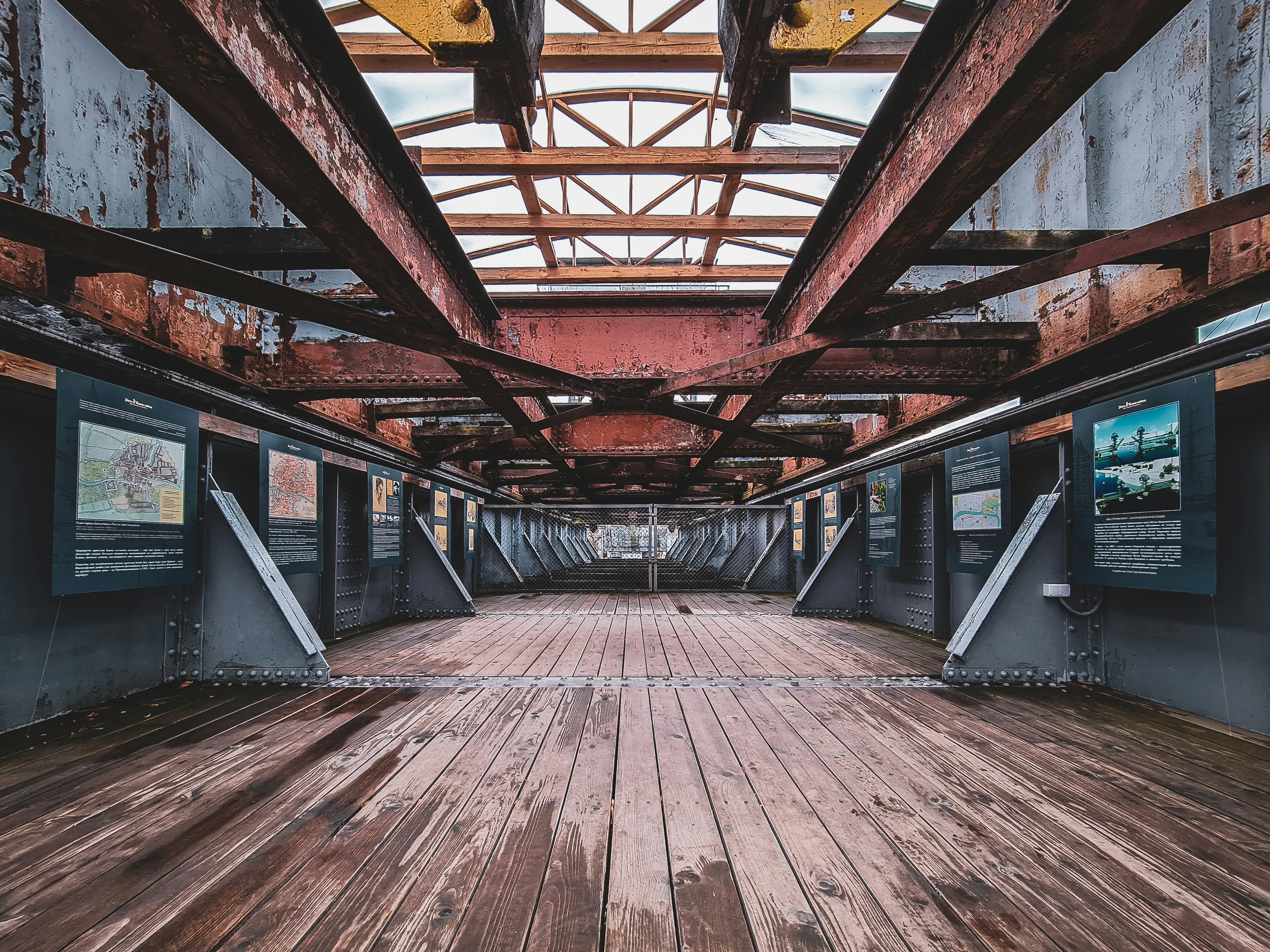 Rust Above the Planks: A Vanishing Corridor of Steel and Light