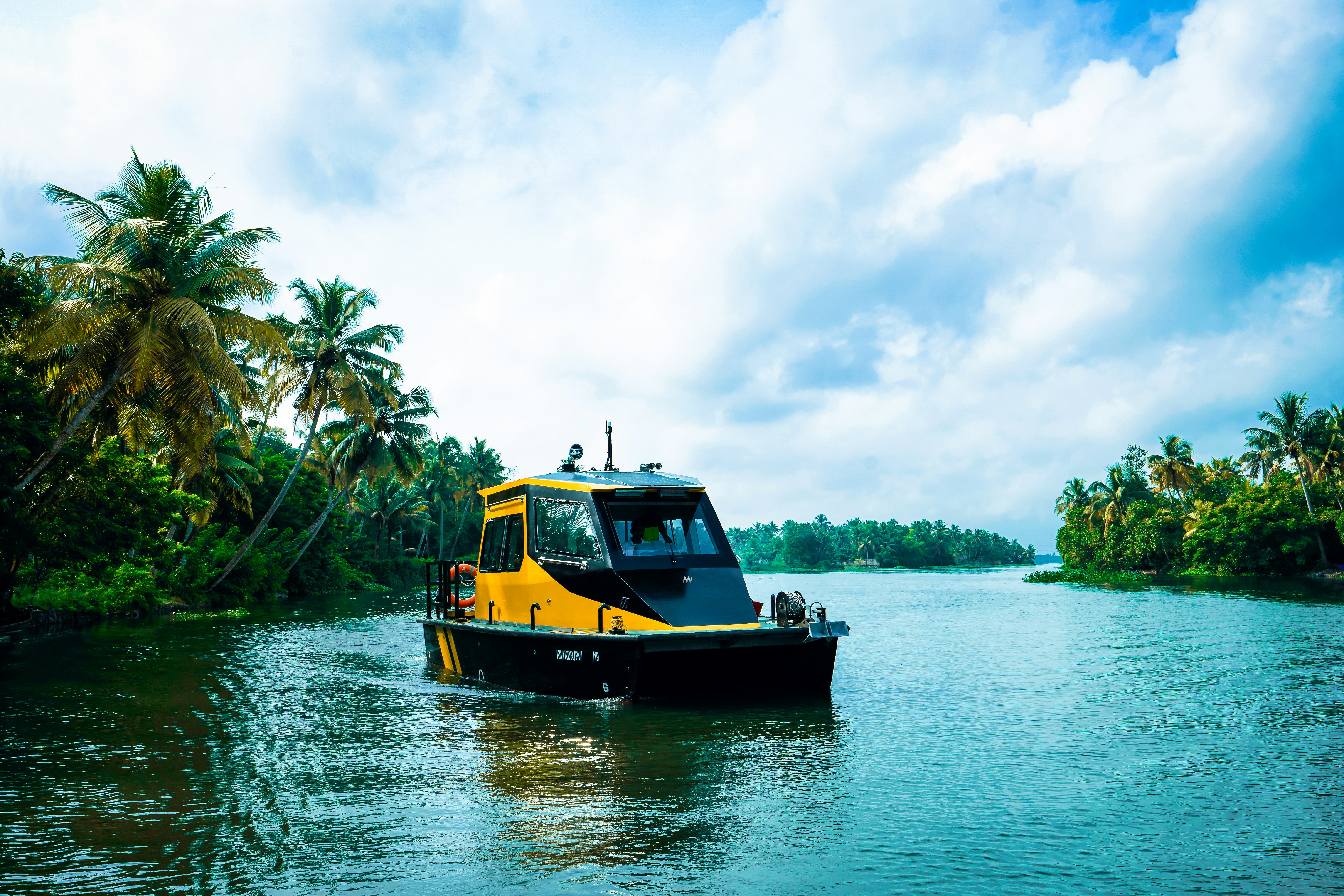 Yellow Workboat on a Turquoise Backwater Framed by Palm-Lined Shores