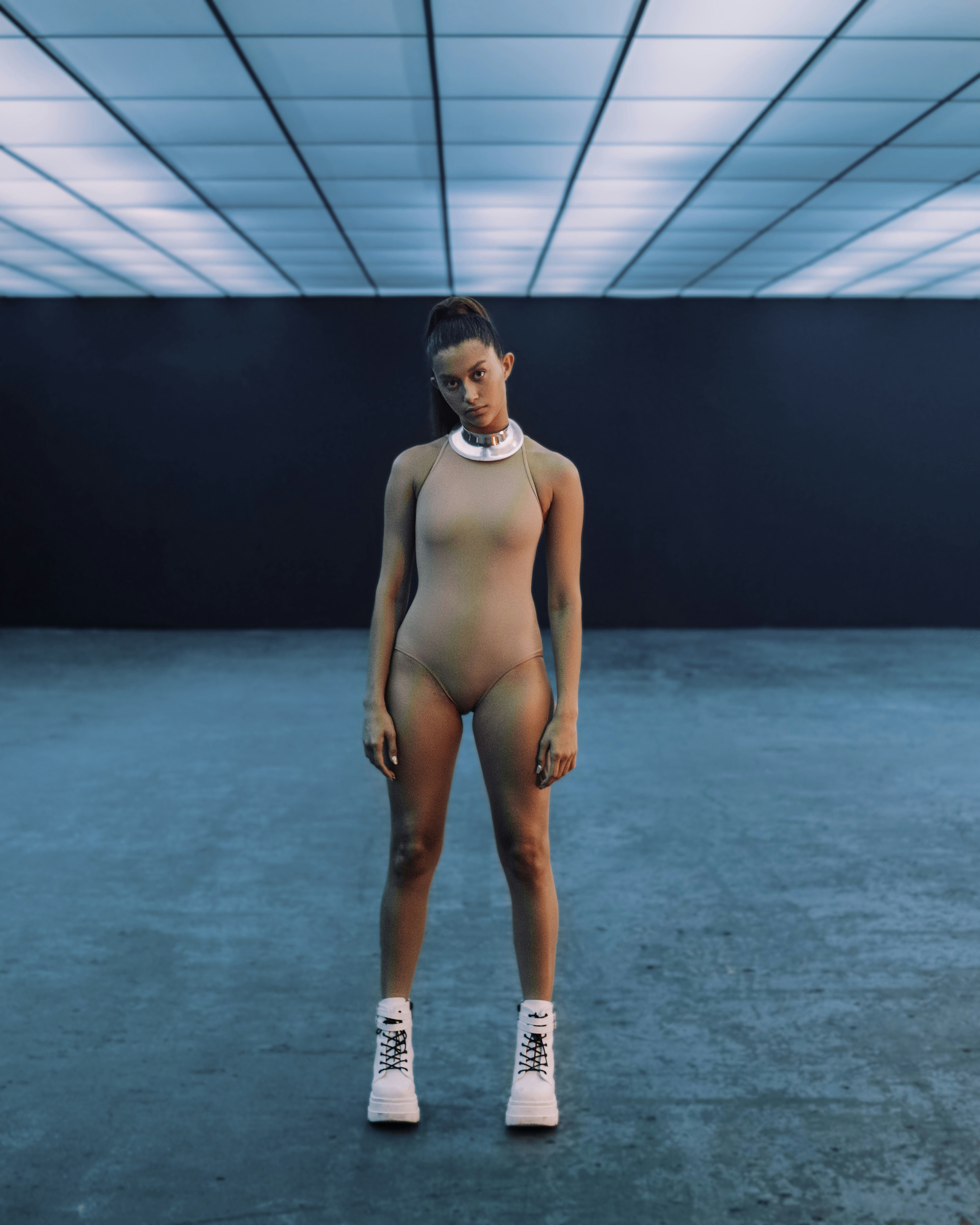 Neon-lit Stance: A lone dancer in a turquoise-tinted studio