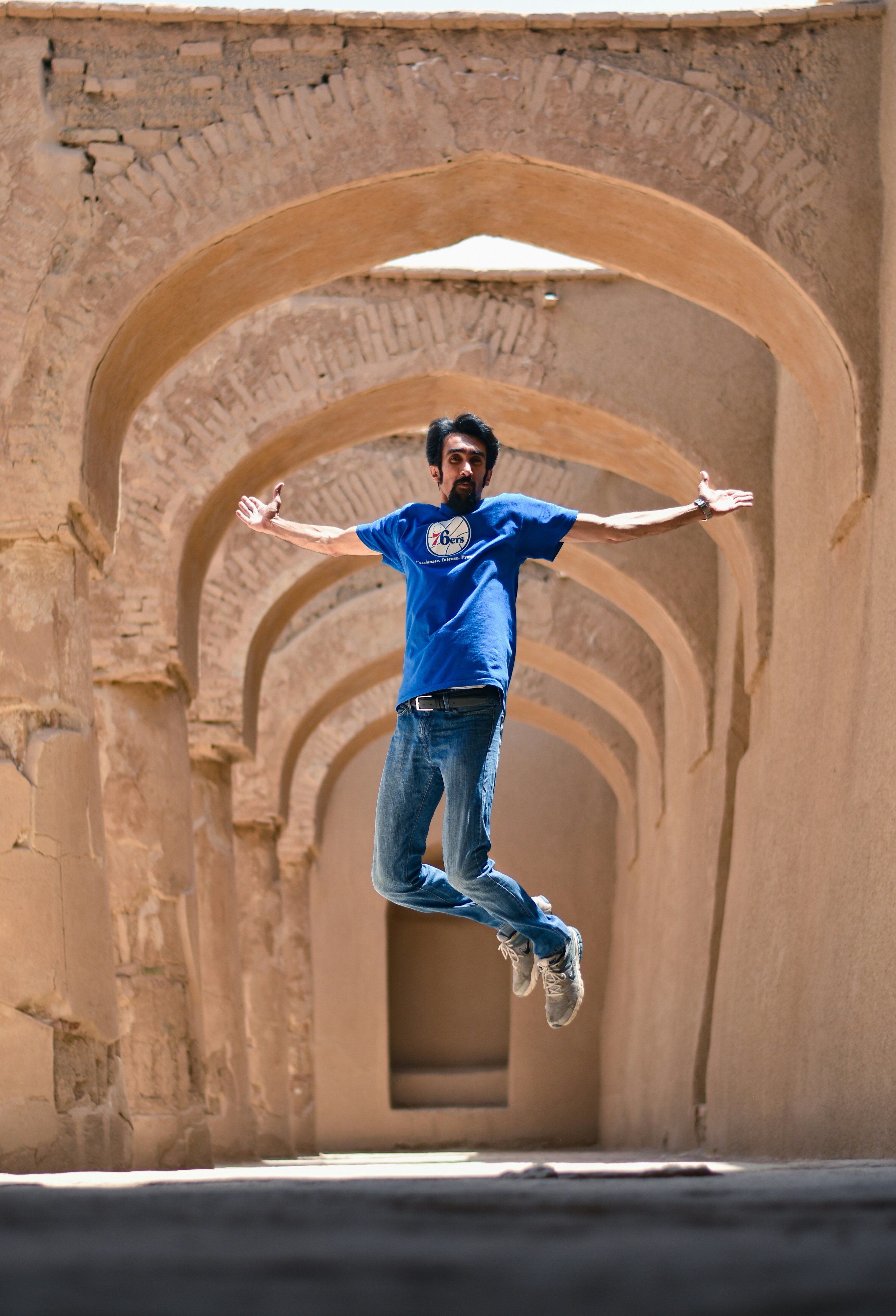 Leap Across Sandstone Arches: An Airborne Moment in a Desert Corridor