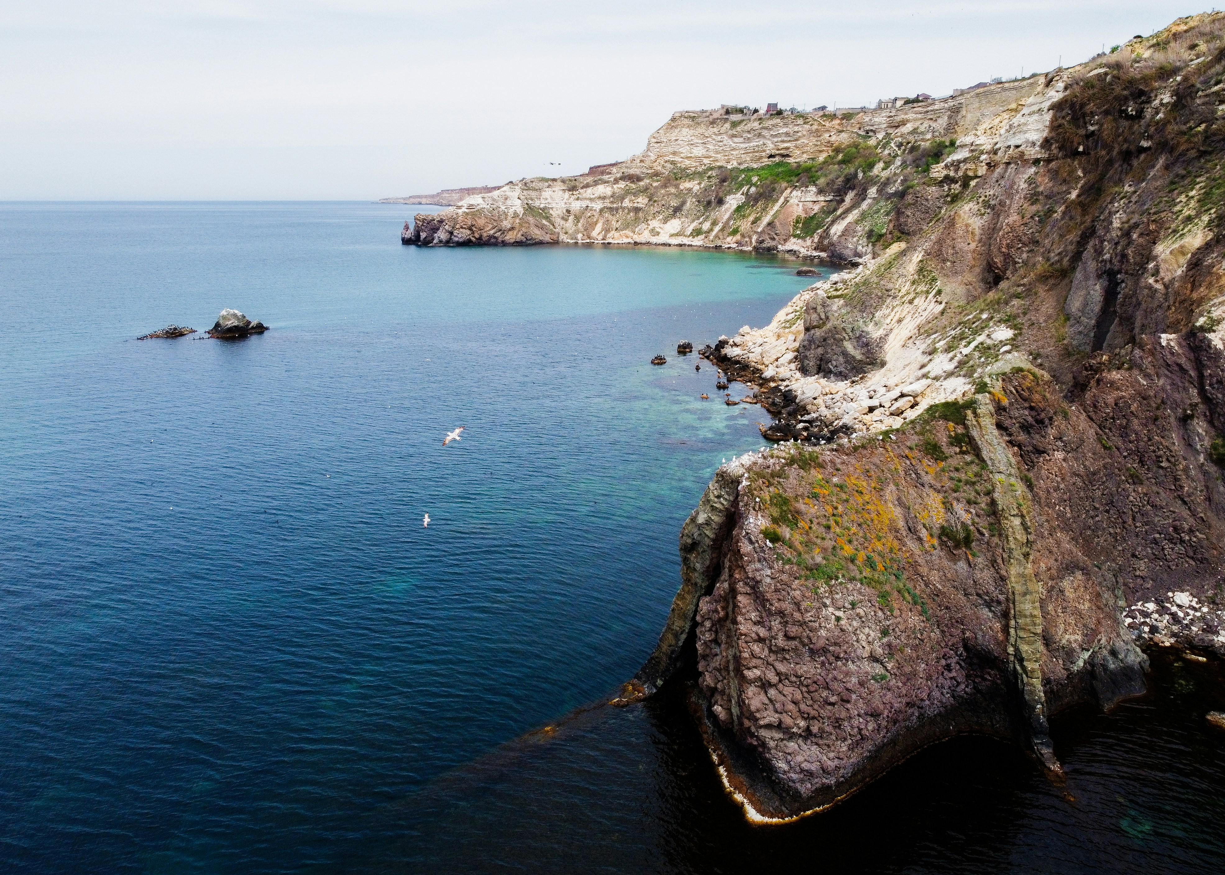 Foto Un acantilado rocoso junto a un cuerpo de agua – Imagen Naturaleza ...