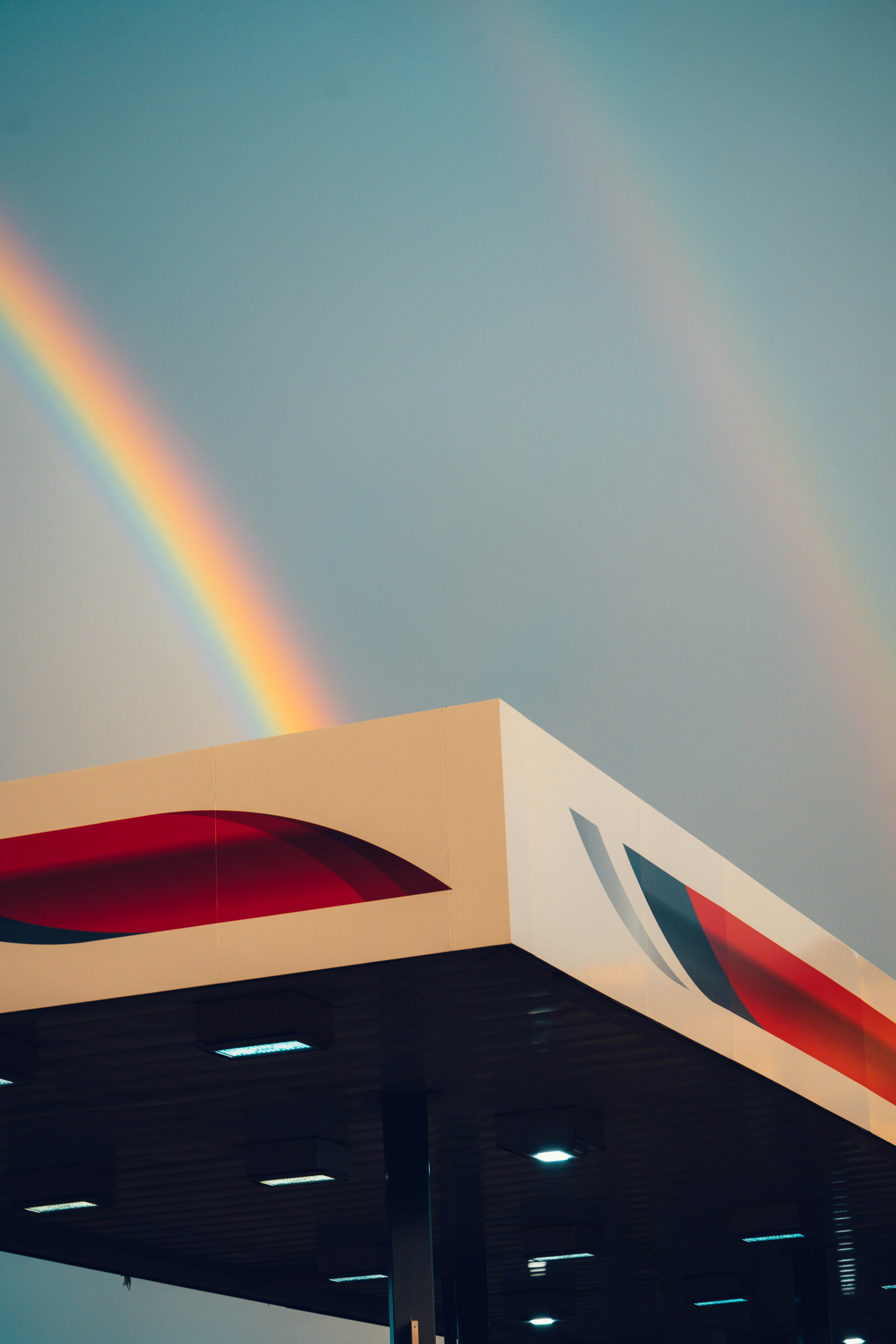 Double Arc: Rainbows Hover Over a Modern Gas Station Canopy