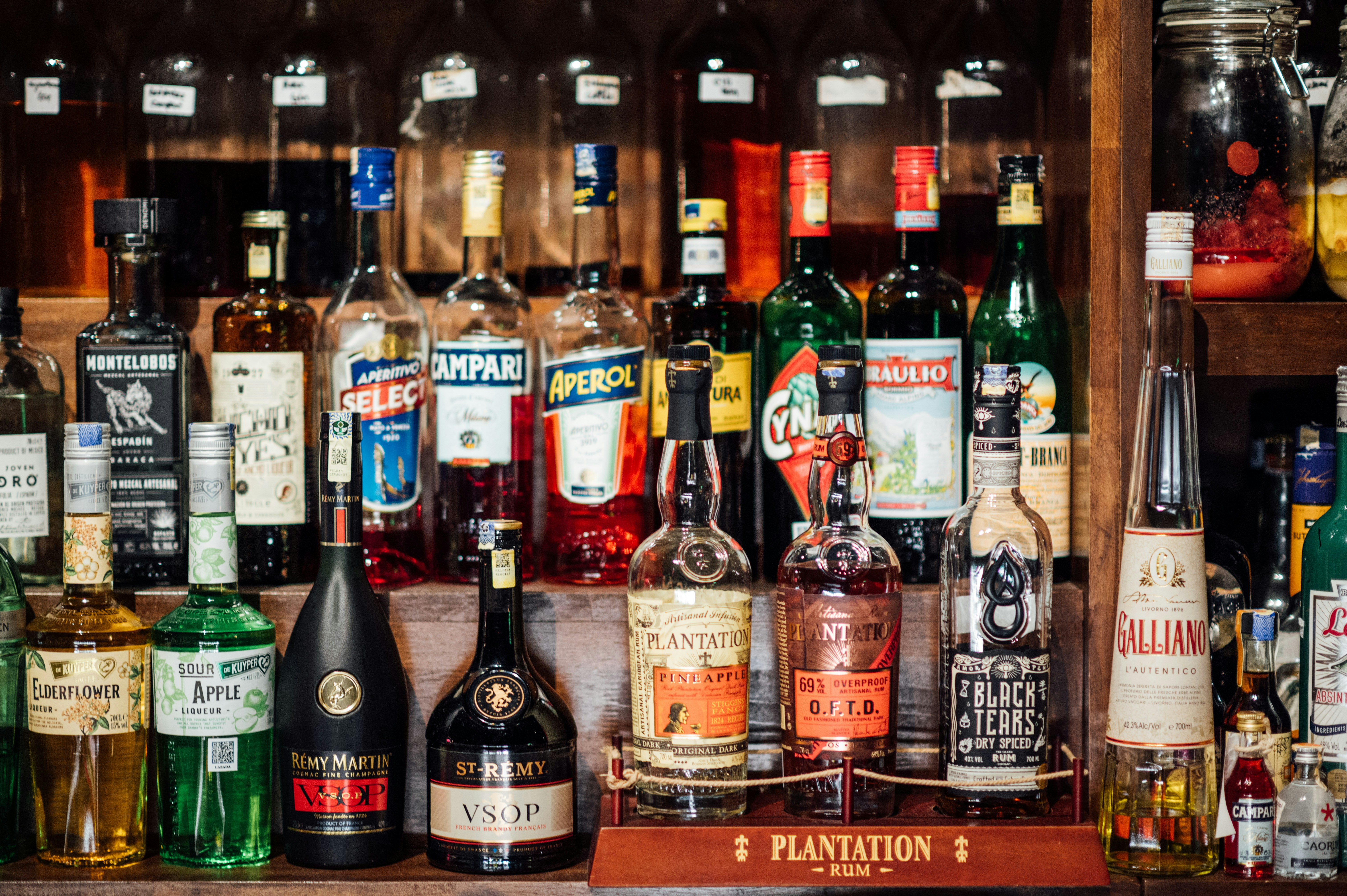 Un groupe de bouteilles sur une étagère photo – Photo Boisson Gratuite ...