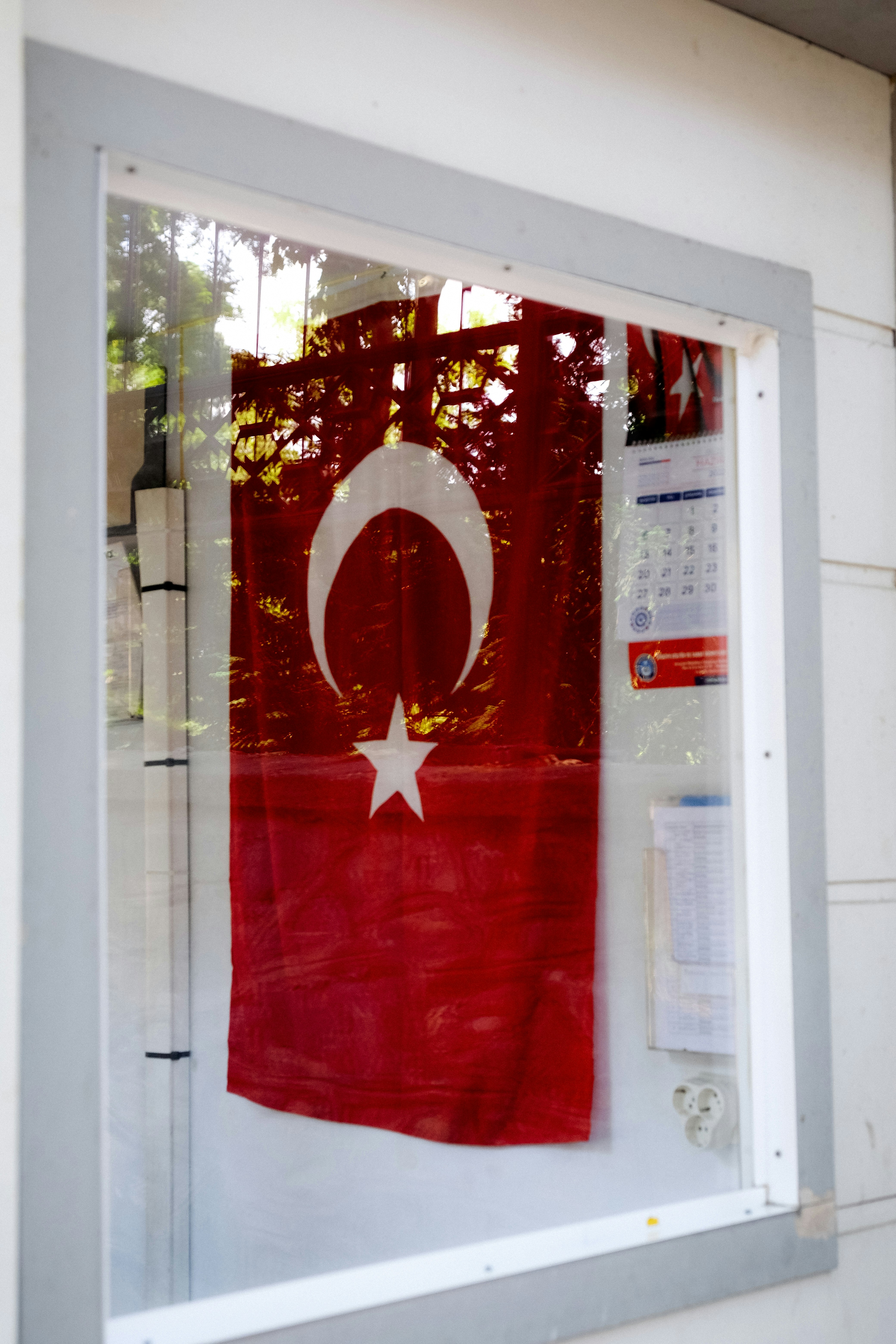 Turkish flag displayed prominently in a window, showcasing its iconic crescent and star against a vibrant red background.